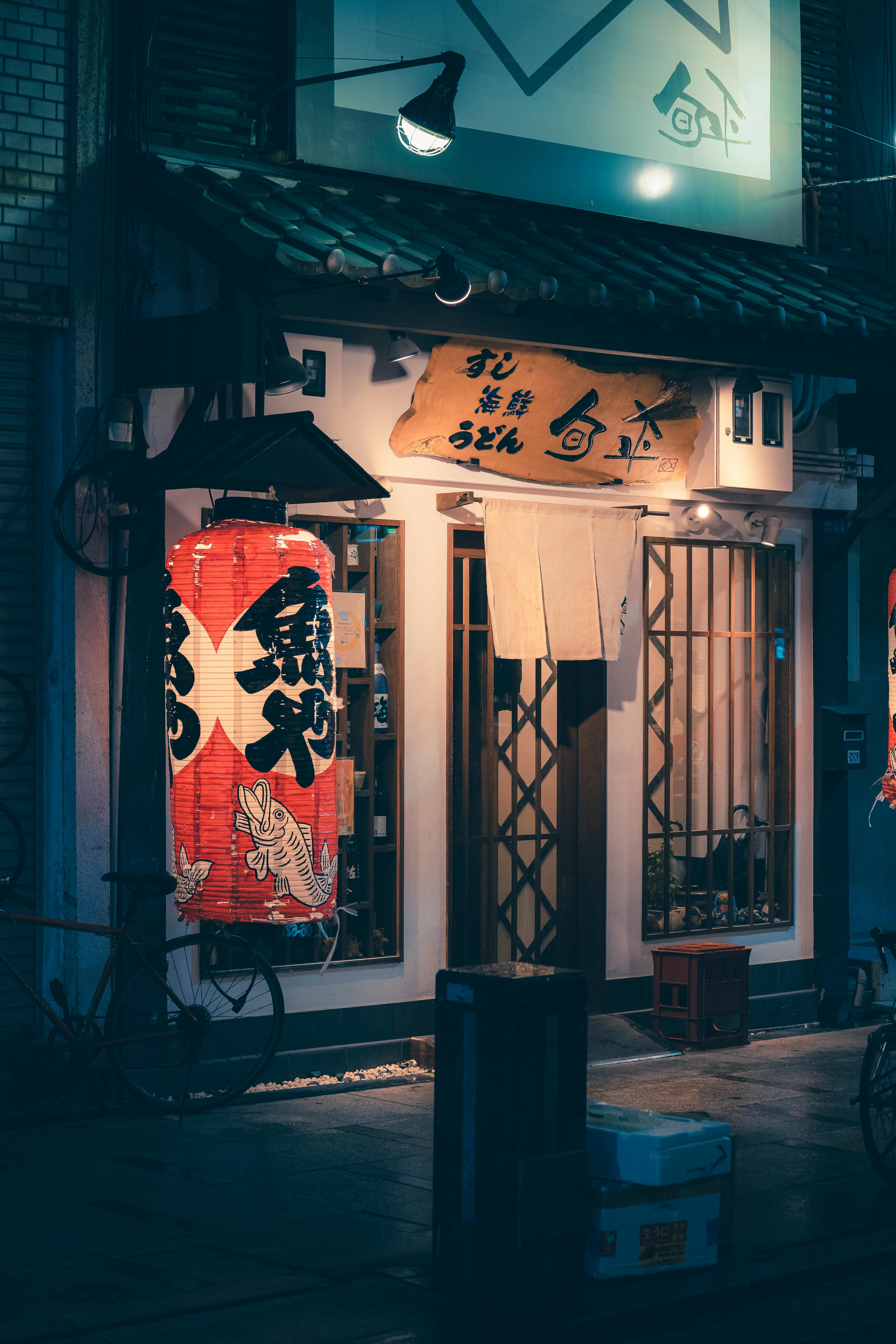 Lantern Glowing in Front of a Closed Store at Night · Free Stock Photo