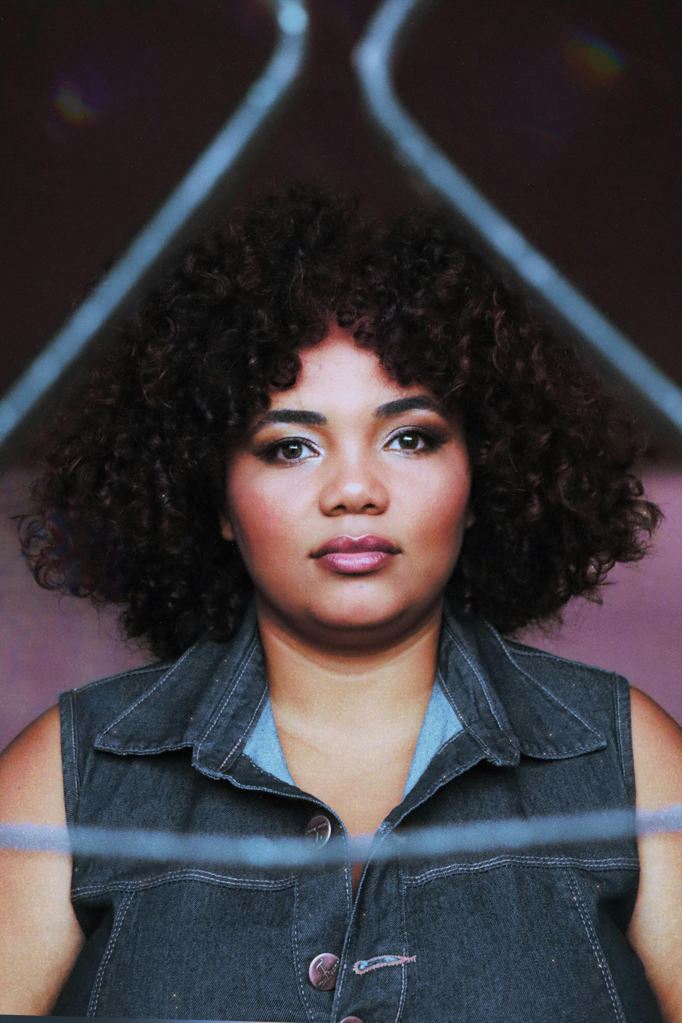 Portrait of Curly Haired Woman in Jeans Crouching · Free Stock Photo