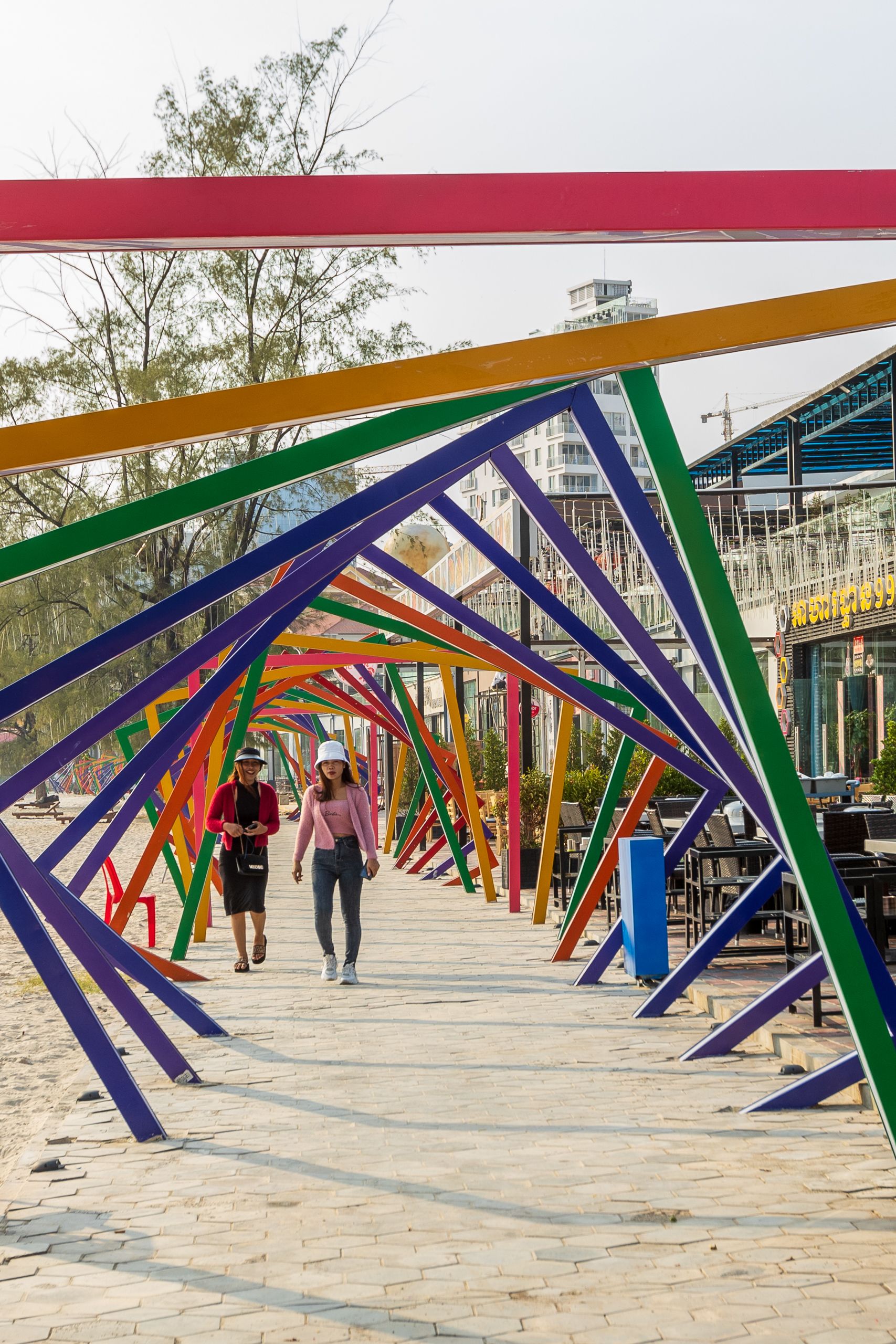 People Walking under Colorful Bars over Alley · Free Stock Photo