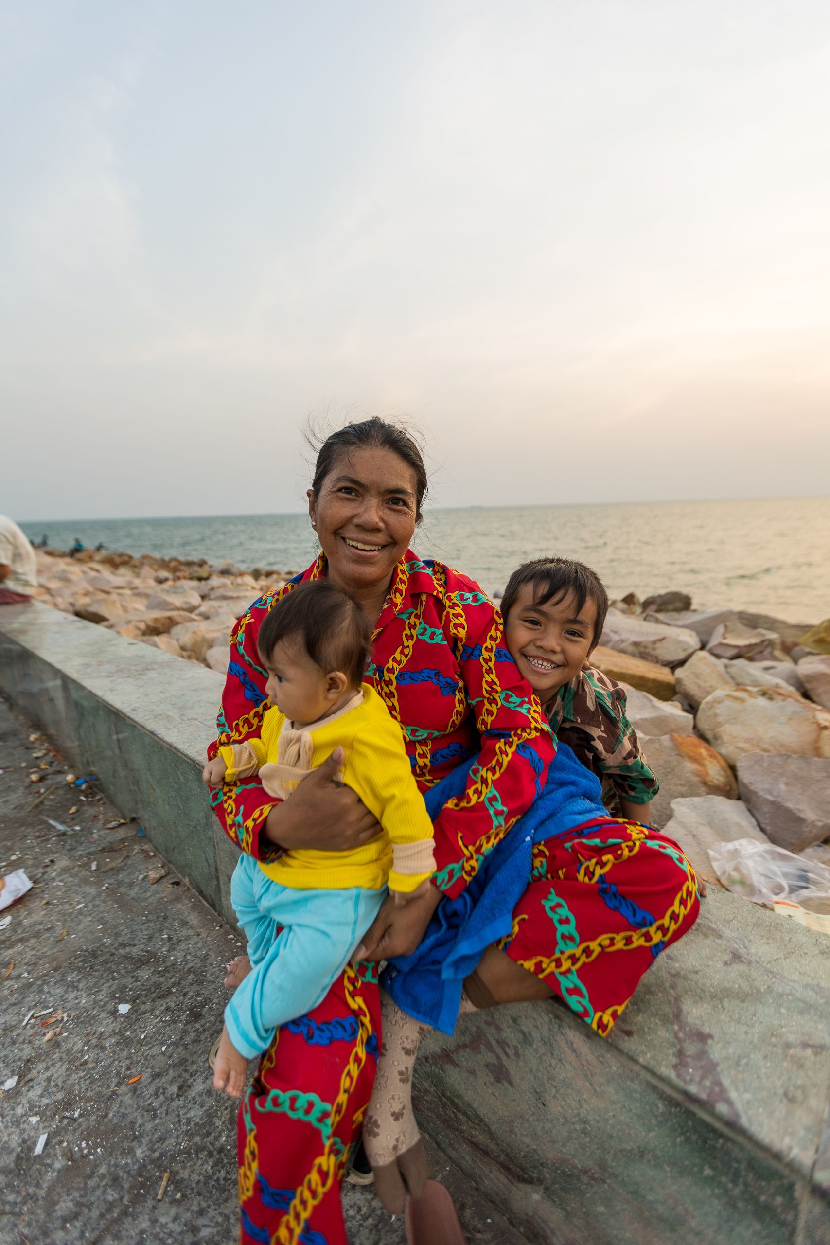 Mother with Her Two Little Kids Sitting on the Seashore at Sunset ...