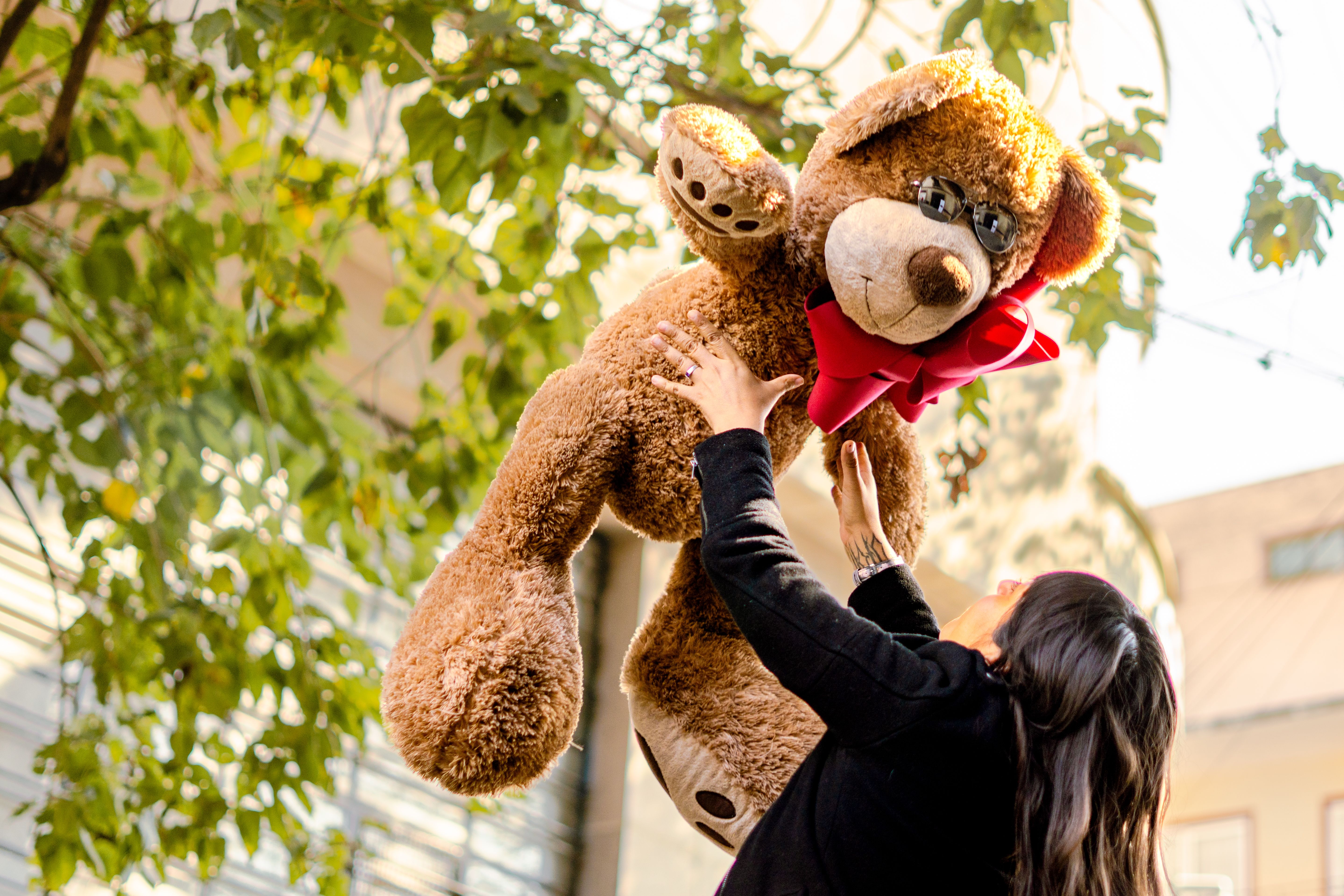 Woman Tossing a Large Teddy Bear in the Air · Free Stock Photo