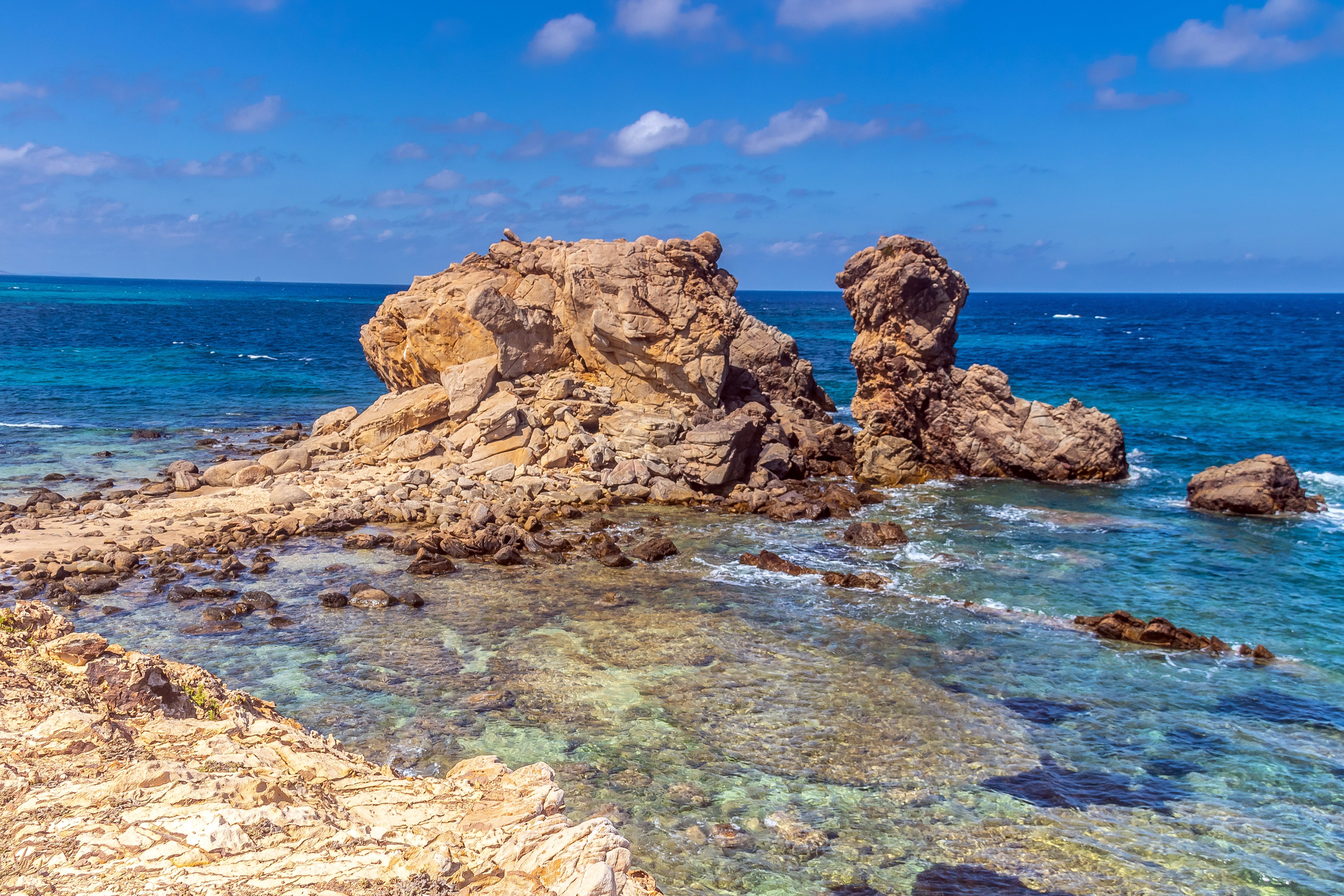 A Rock Formation on the Shore and the Seascape under a Blue Sky · Free ...
