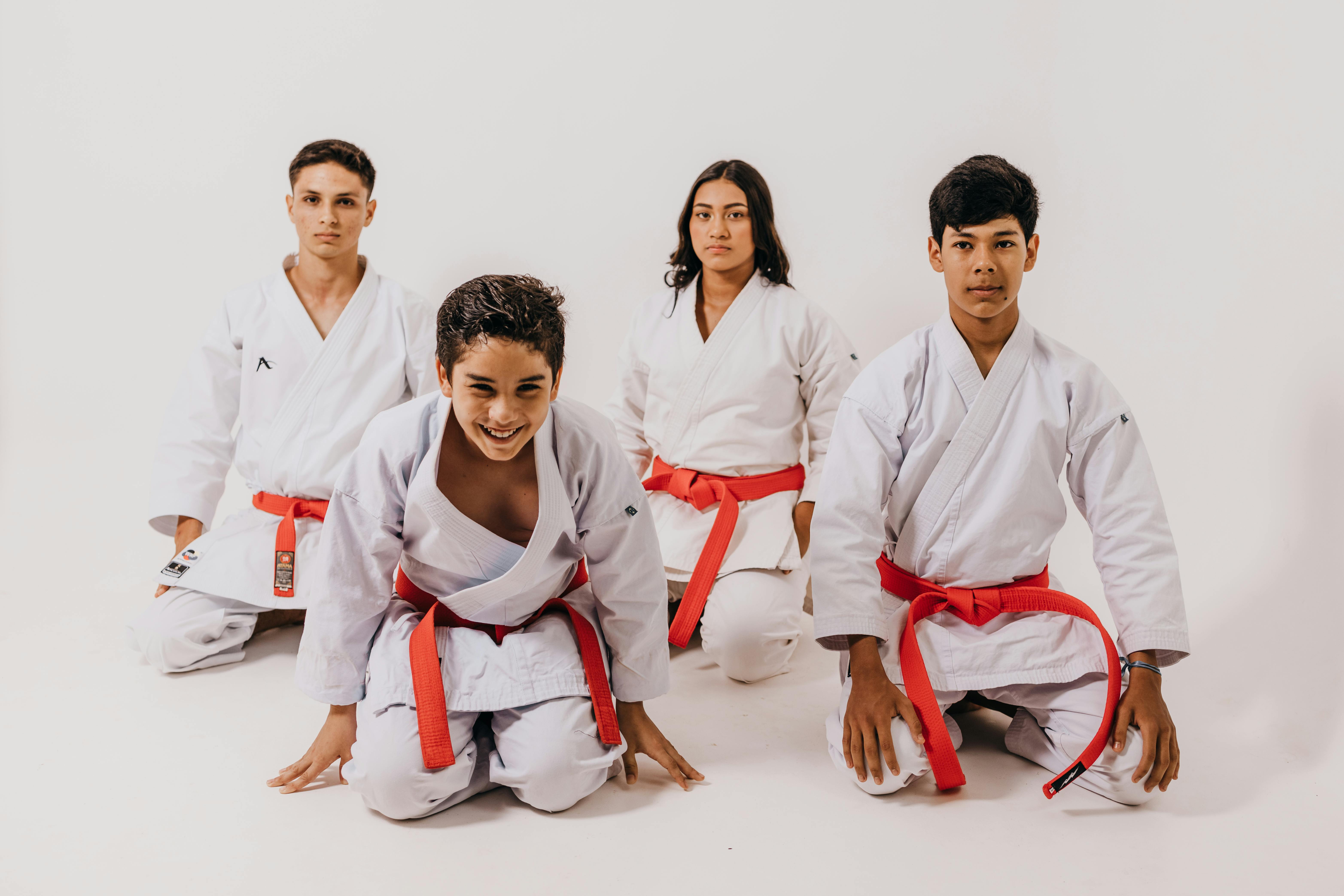 Group of Teenage Karate Students Sitting on the Floor · Free Stock Photo