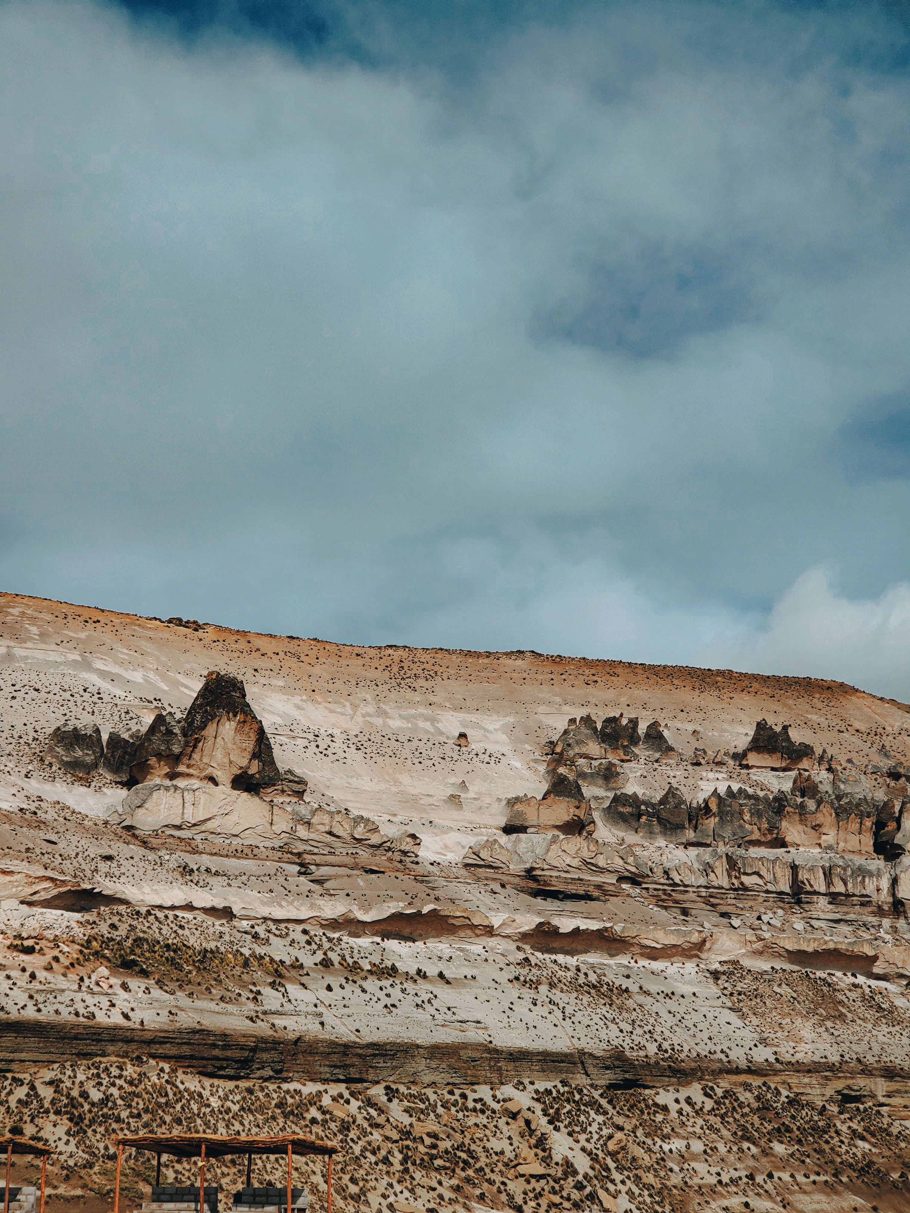 Field at the Bottom of a Sandstone Hill · Free Stock Photo