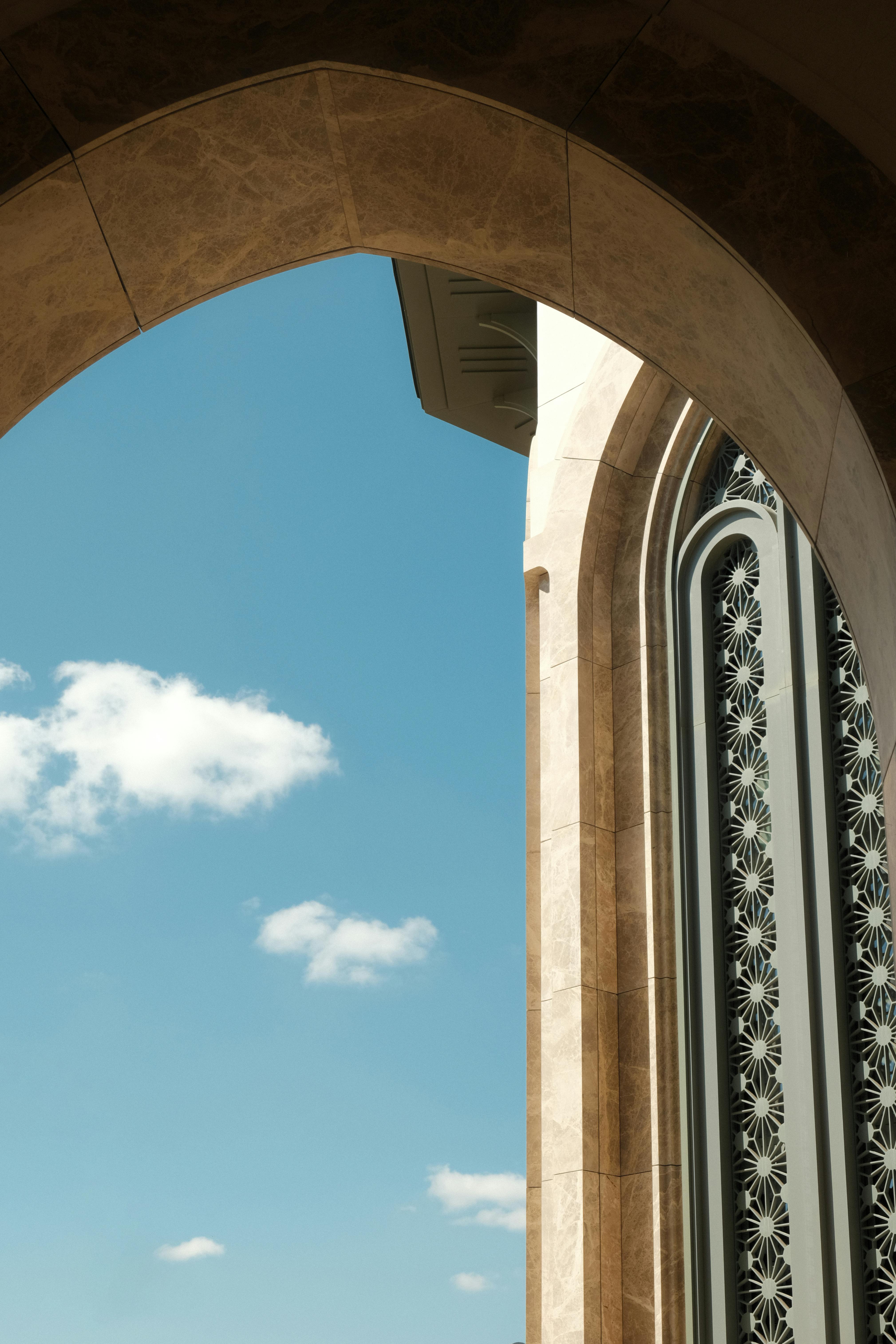 Sunlit Building Wall behind Arch · Free Stock Photo