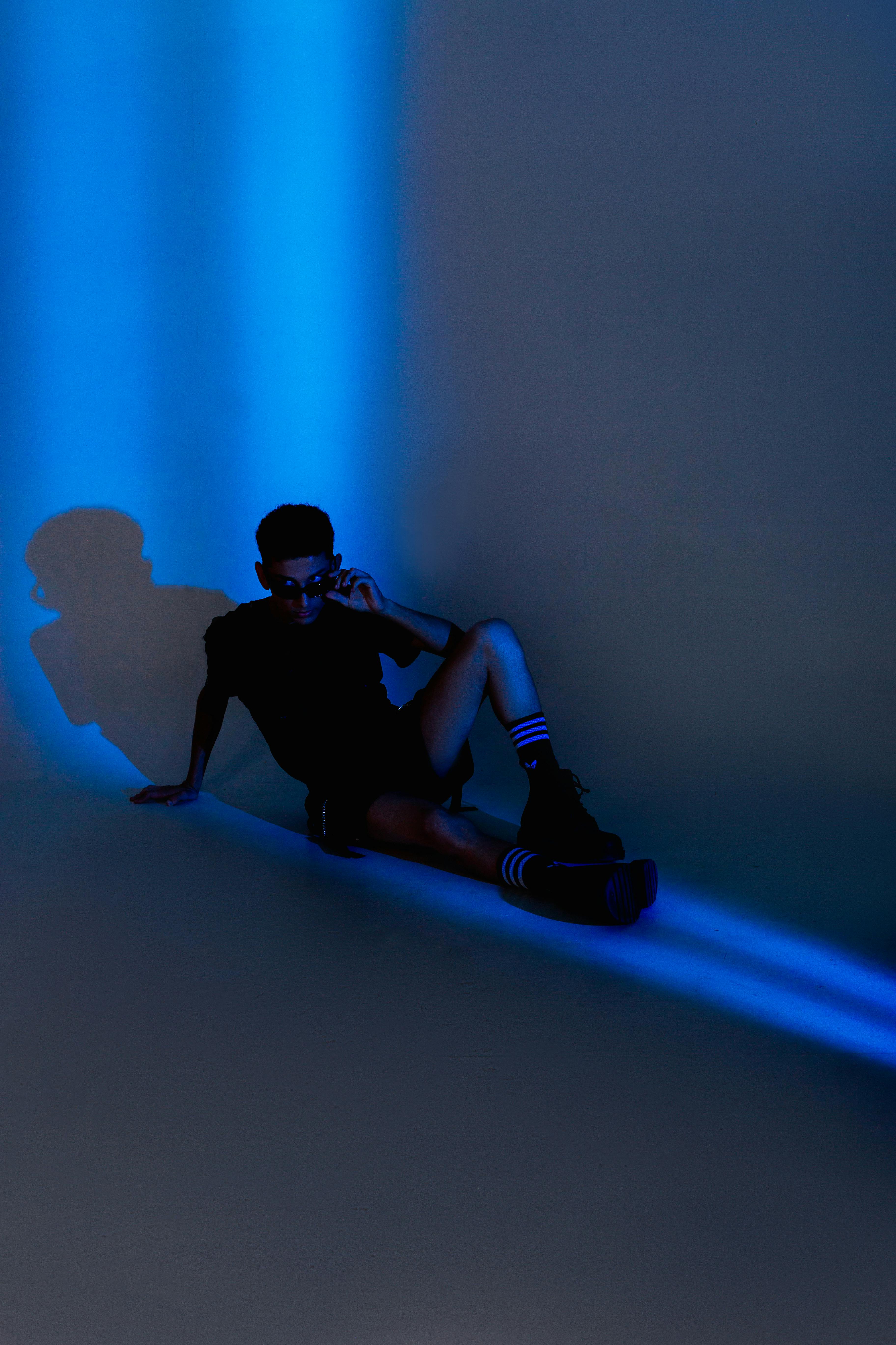 Man Lying in Studio Illuminating with Blue Light · Free Stock Photo
