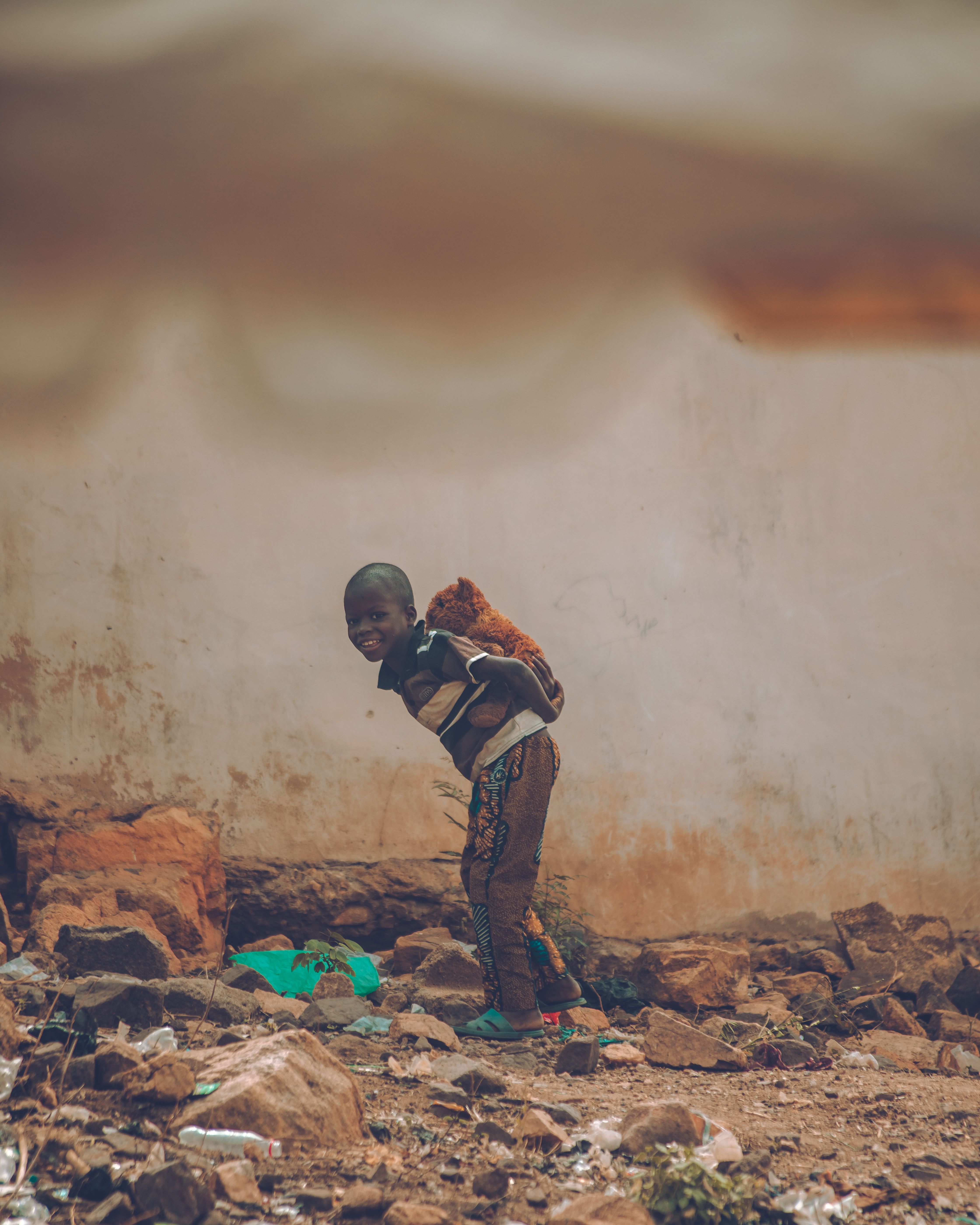A child is standing in the rubble of a building · Free Stock Photo
