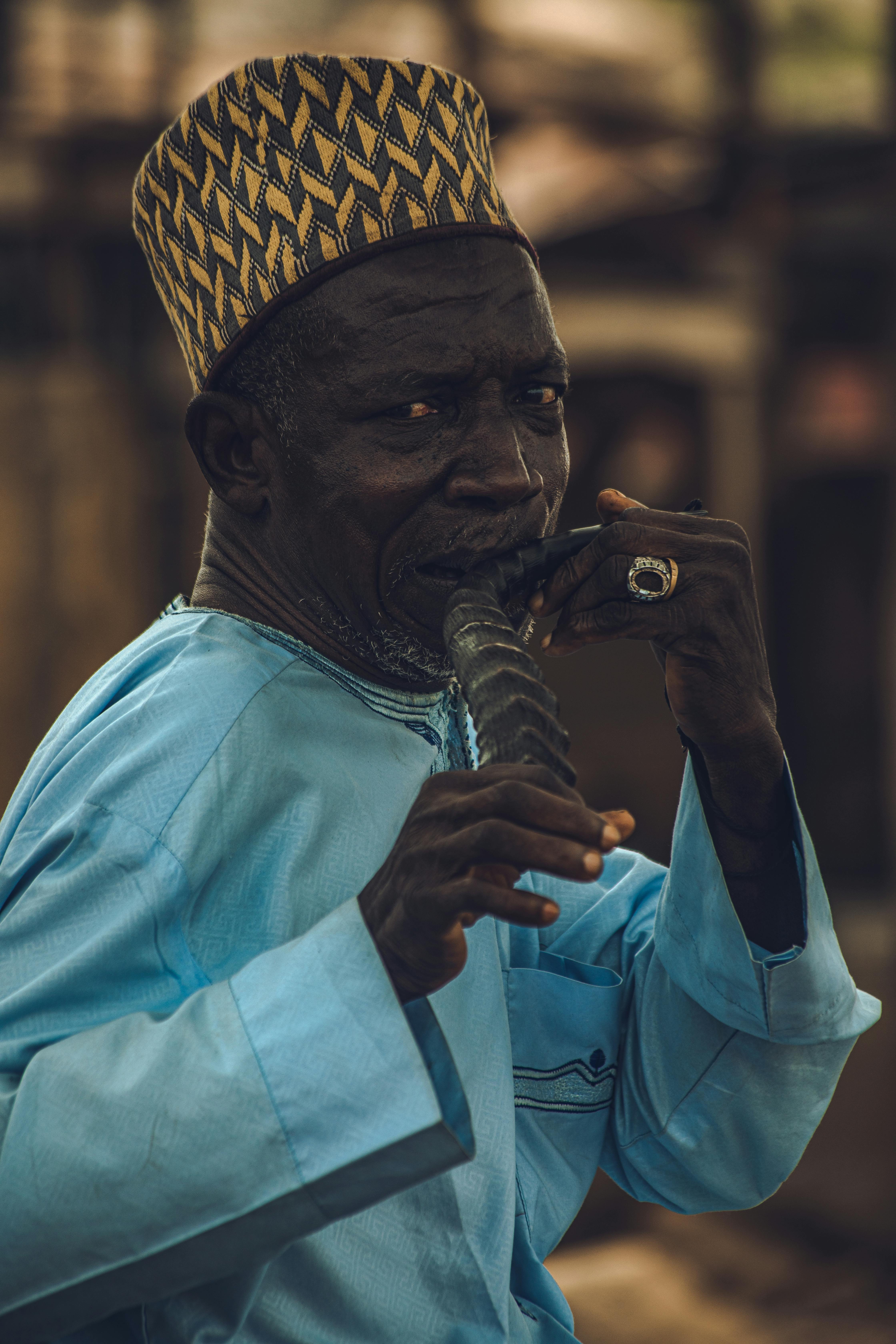 Man in Traditional Clothing Playing an Instrument · Free Stock Photo
