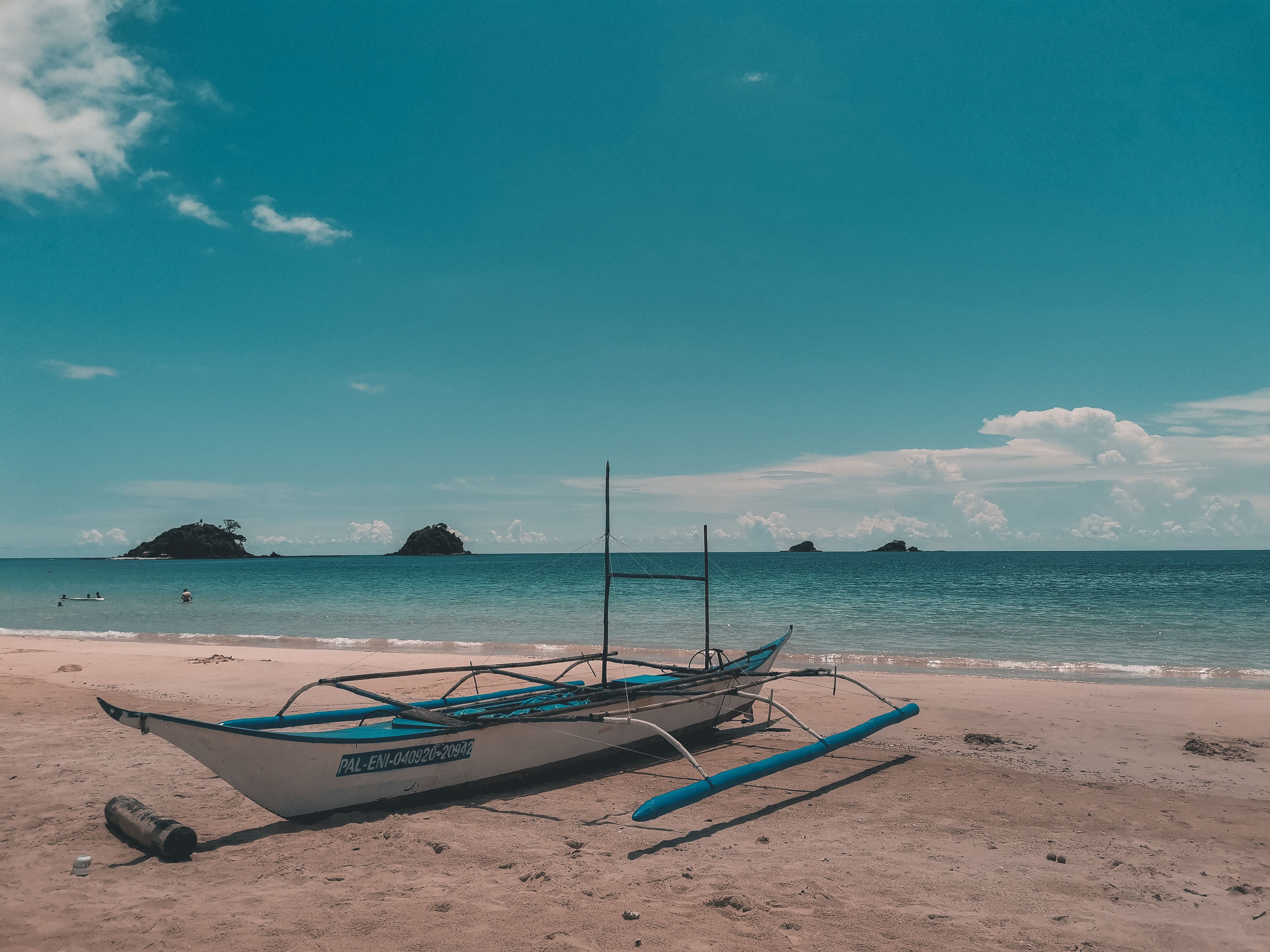 A Boat on the Beach and View of Island on the Horizon · Free Stock Photo