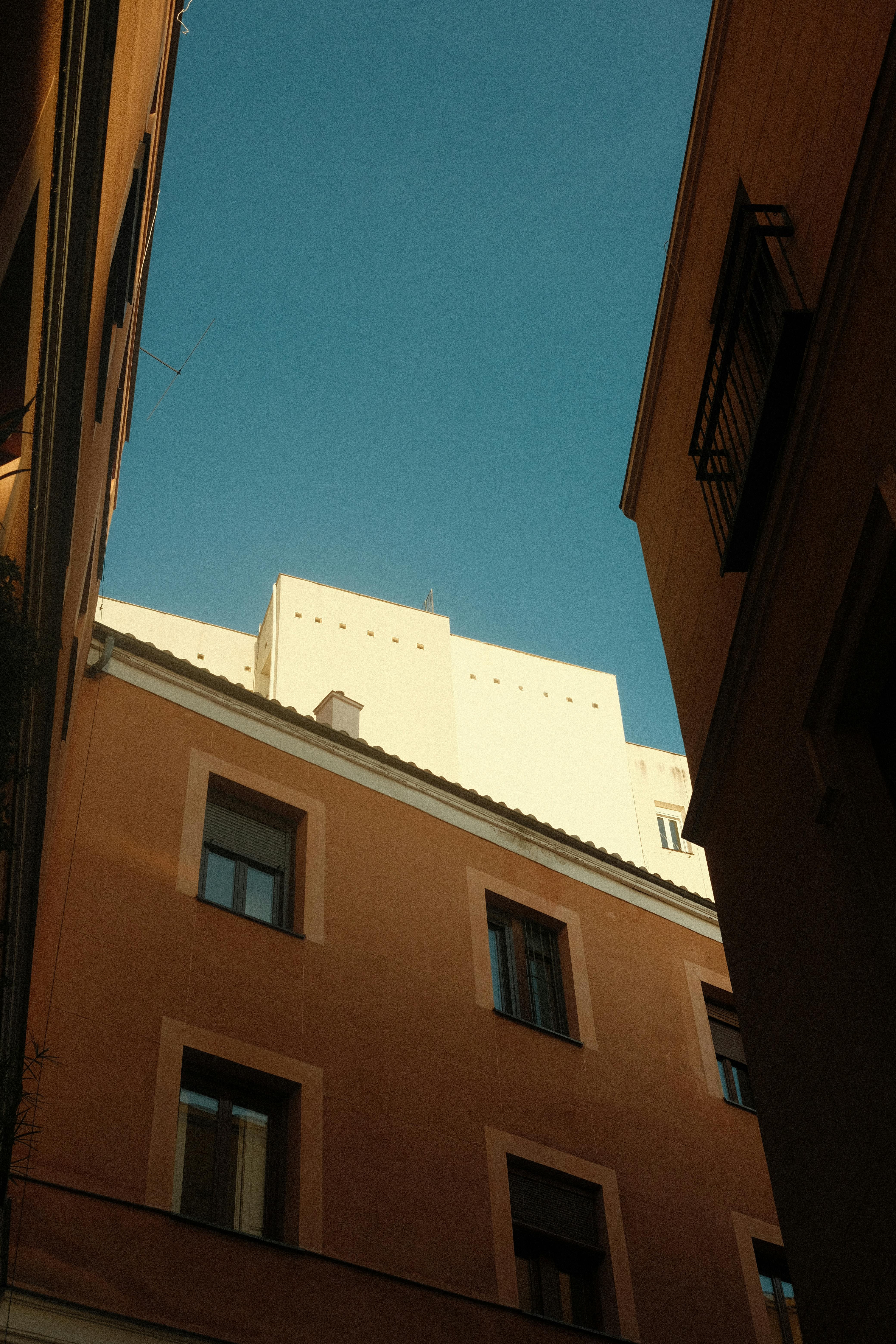 Low Angle View of Blue Sky in Space between Buildings · Free Stock Photo