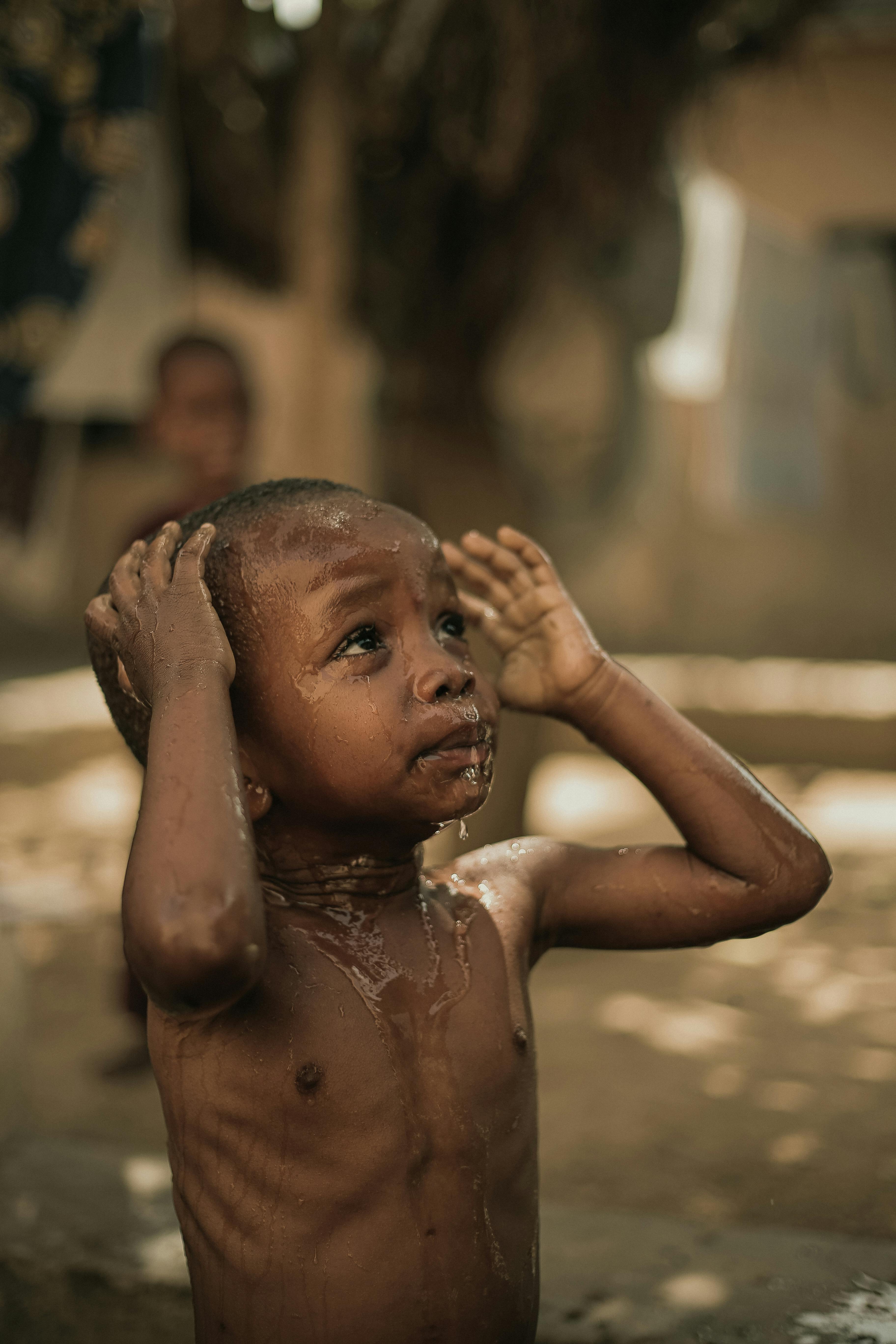 Child Sprinkling Himself with Water · Free Stock Photo