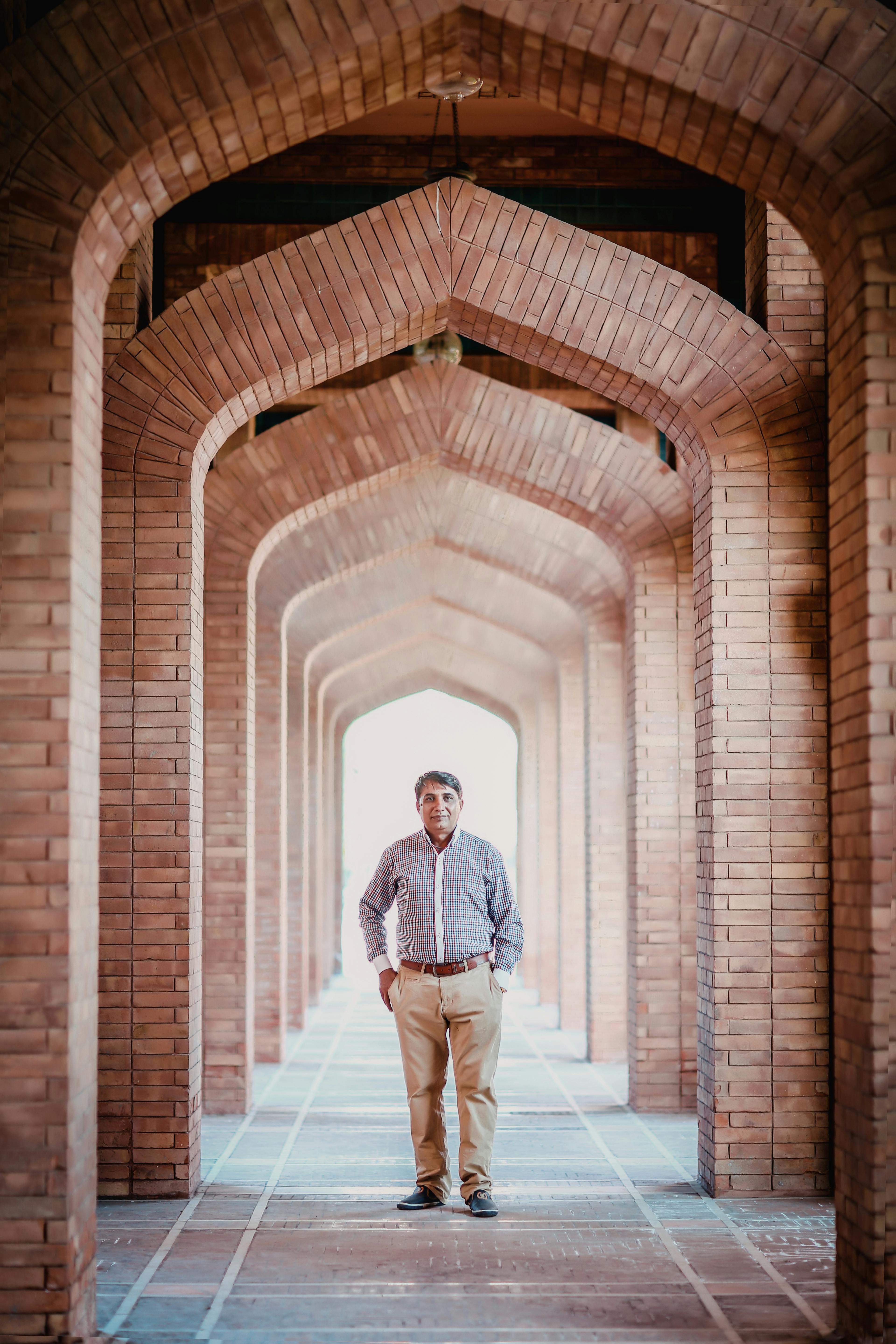 Man Standing in Concrete Arches · Free Stock Photo