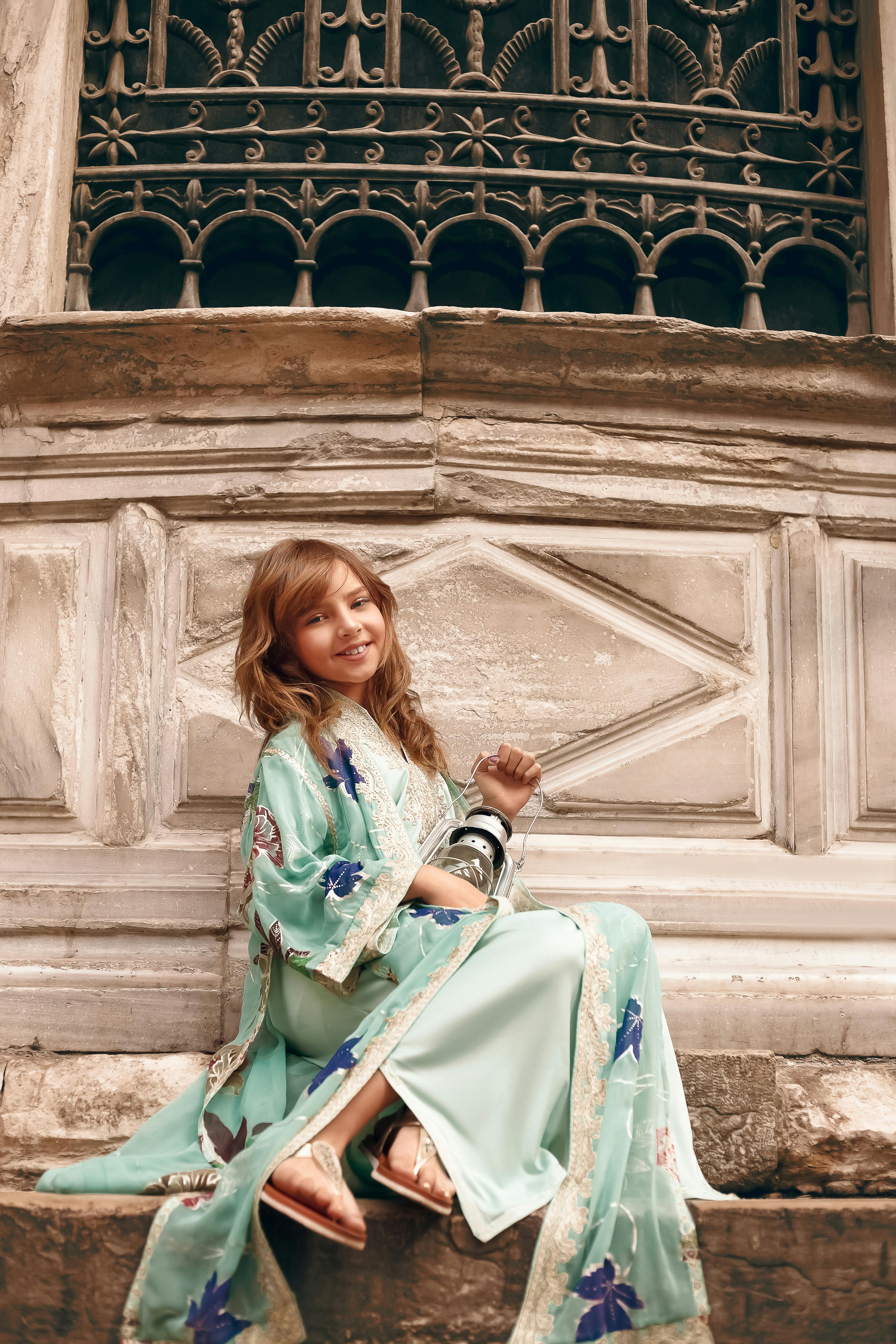 Smiling Child Model Posing in Satin Dress · Free Stock Photo
