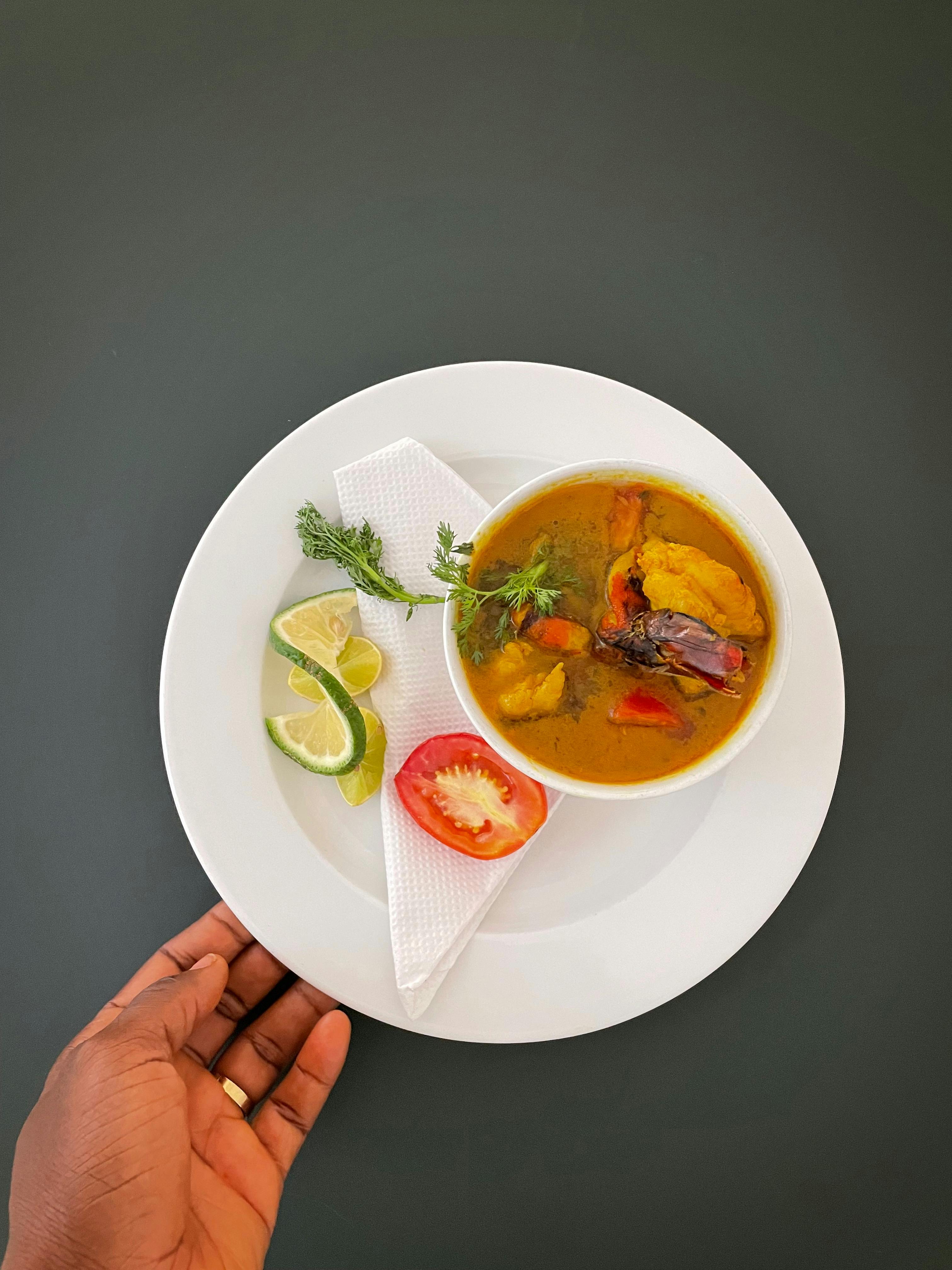 Bowl of Stew with a Slice of Lime and Tomato · Free Stock Photo