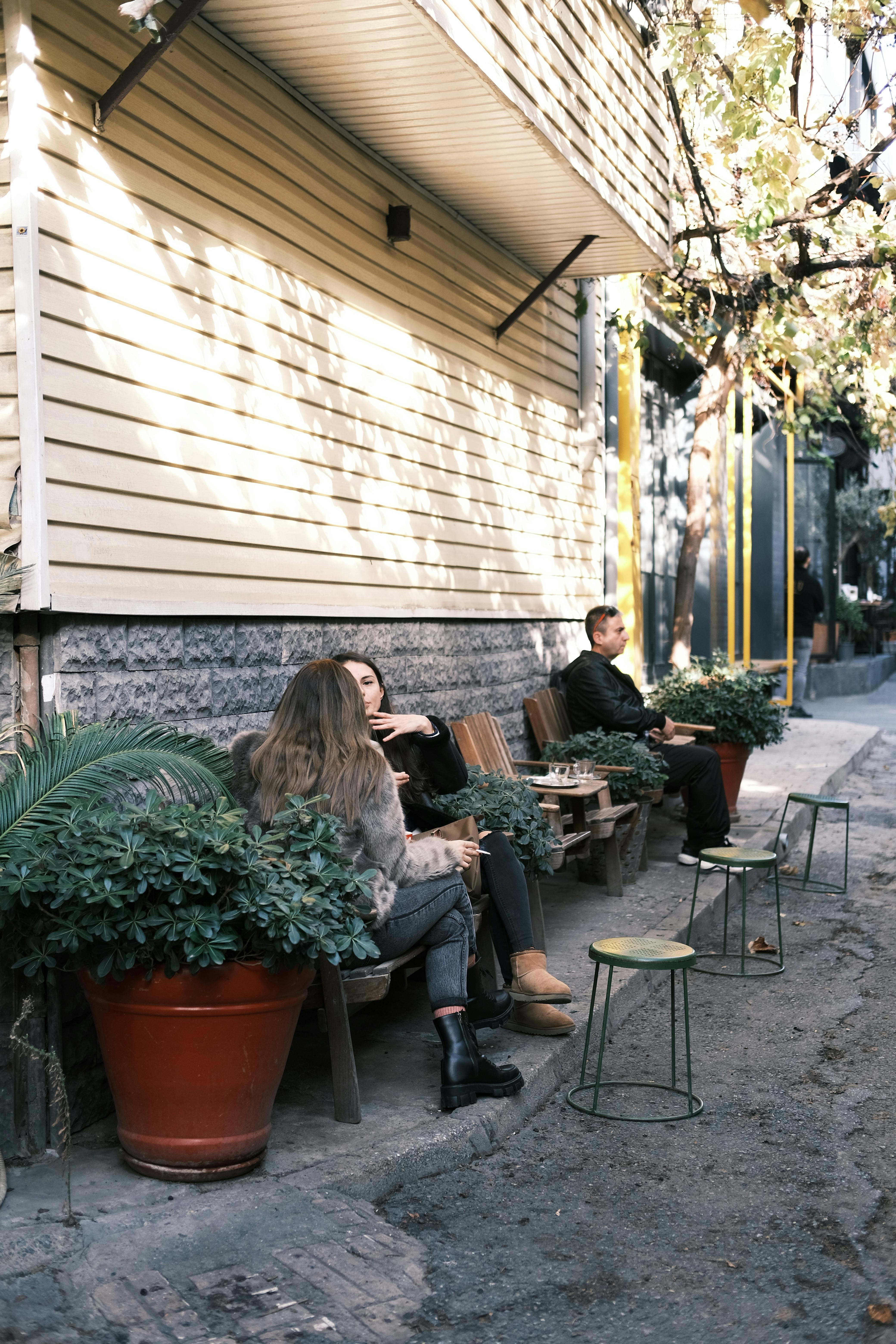 People Relaxing Outside a Sidewalk Cafe · Free Stock Photo
