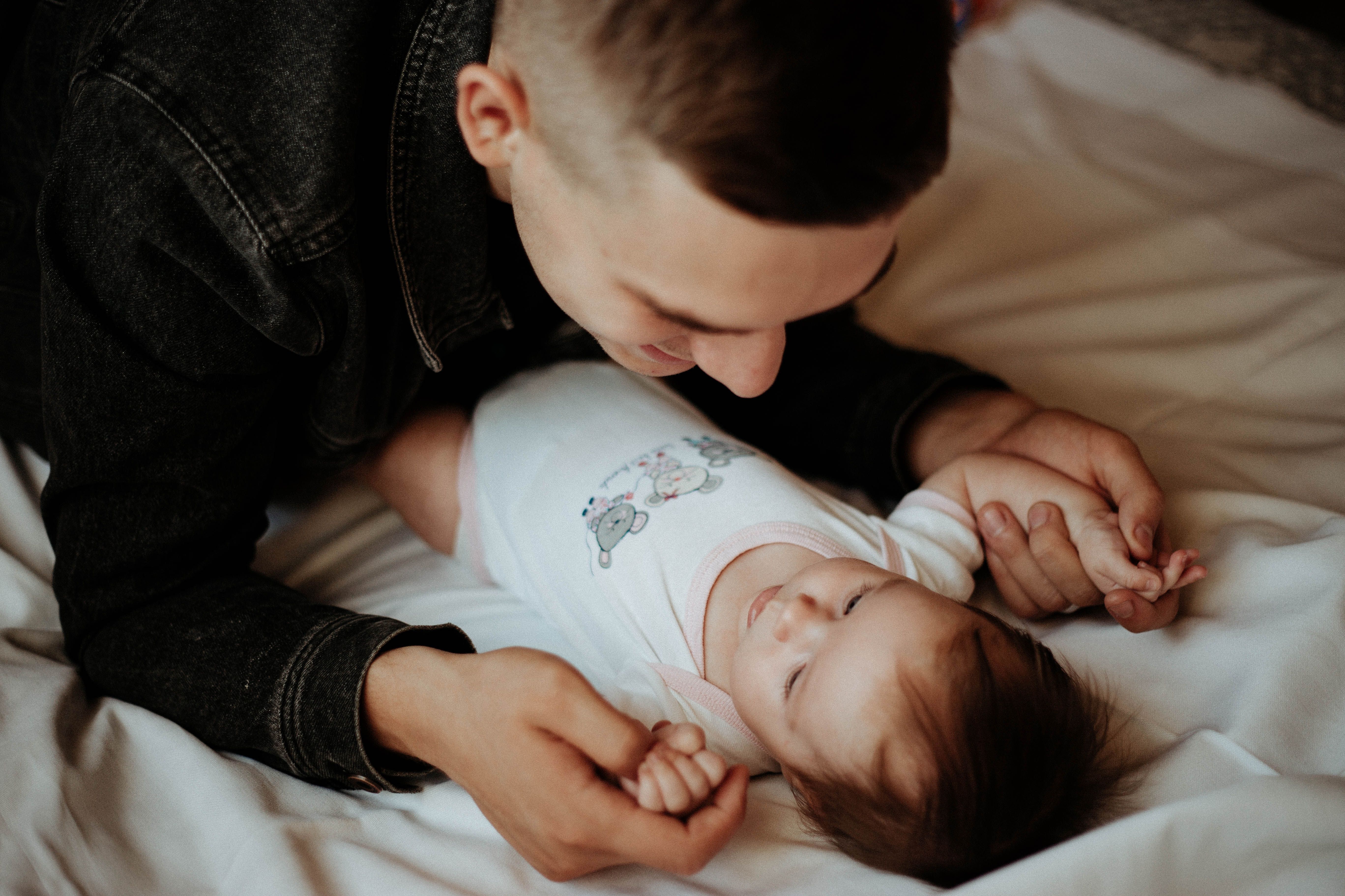 Father Lying with His Little Baby and Smiling · Free Stock Photo