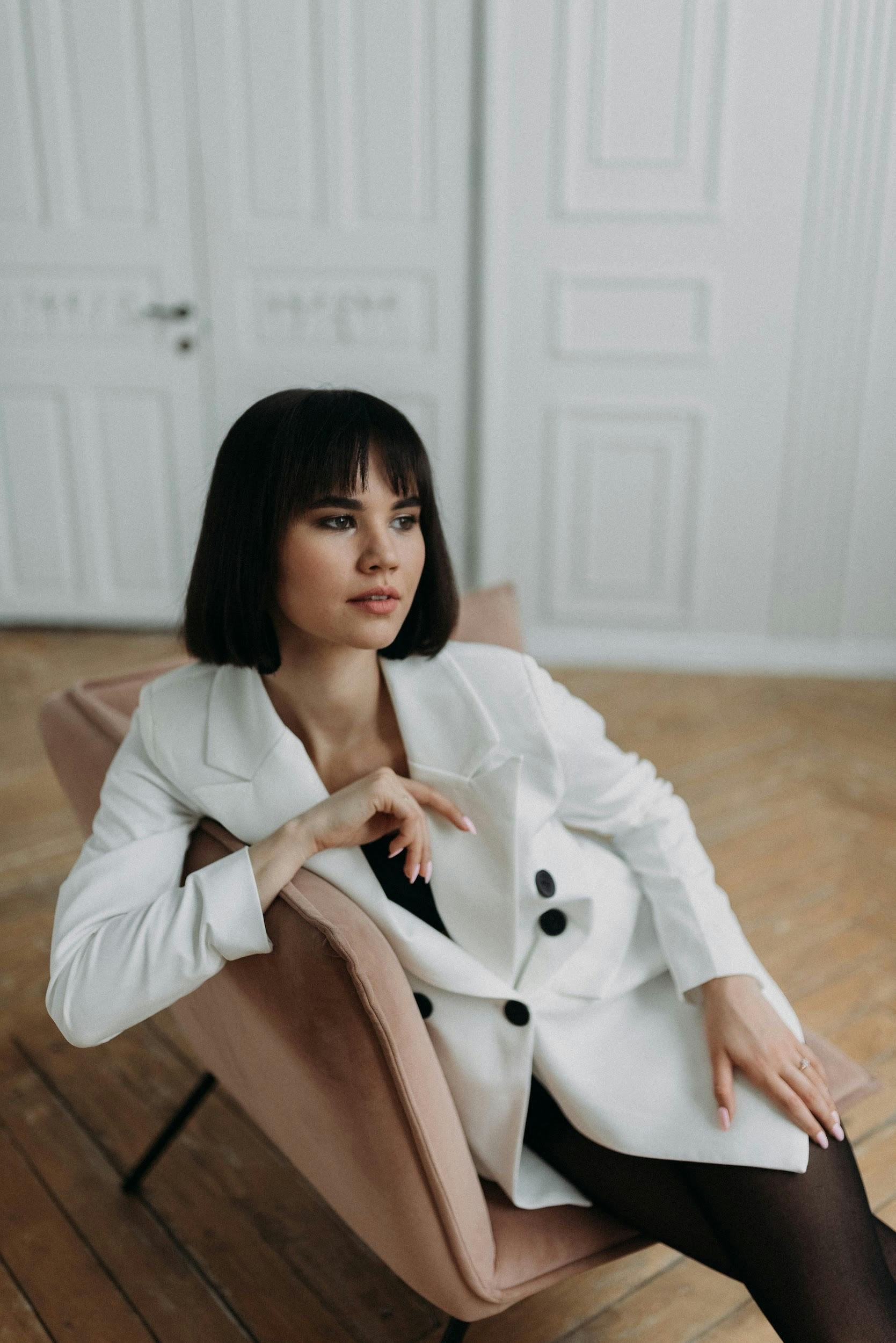Beautiful Young Woman Sitting on Chair in Studio · Free Stock Photo