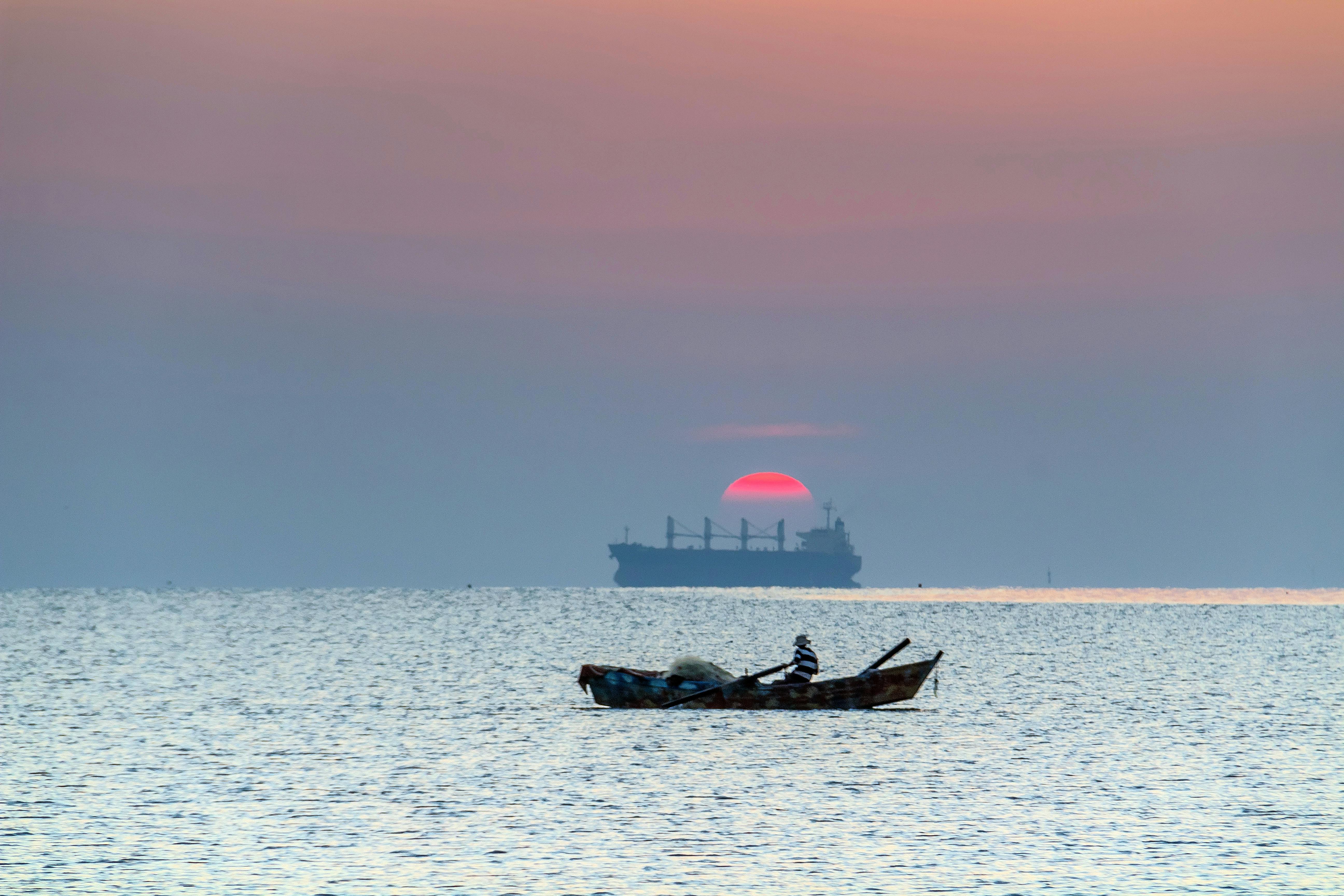 Man Rowing a Boat on the Sea at Sunset · Free Stock Photo