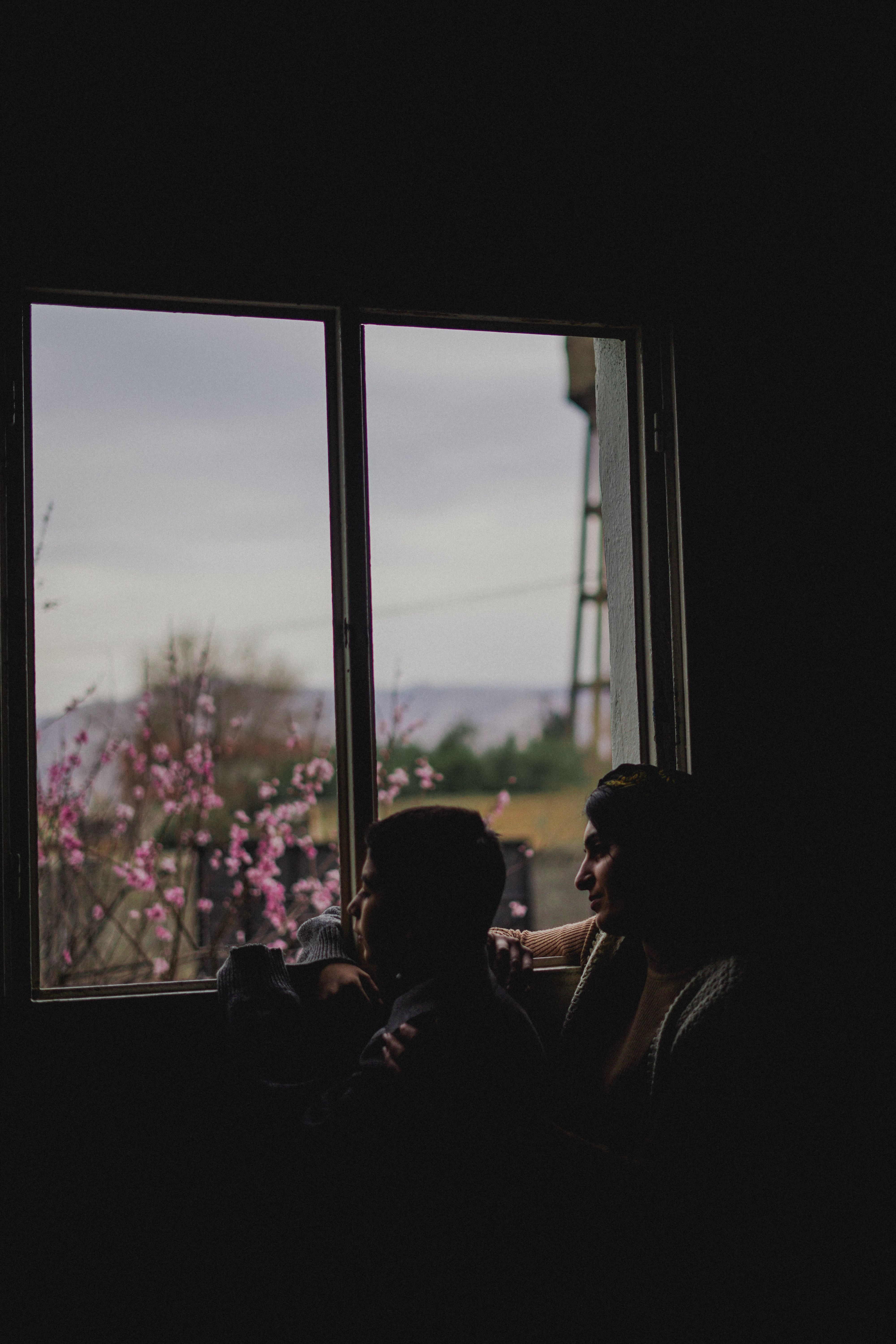 Couple Sitting Together by Windows in Room Darkness · Free Stock Photo