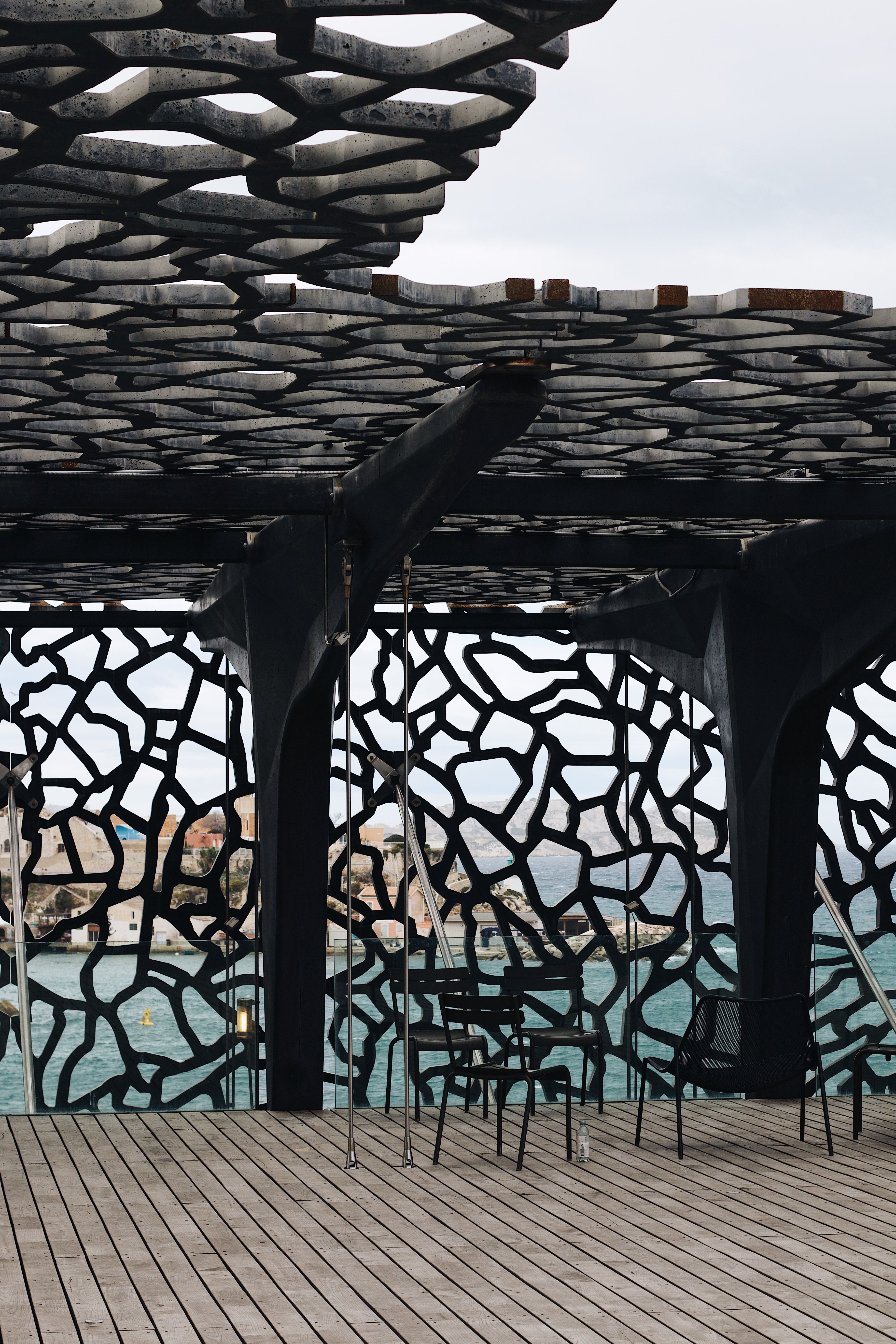 A wooden structure with a metal roof and chairs · Free Stock Photo