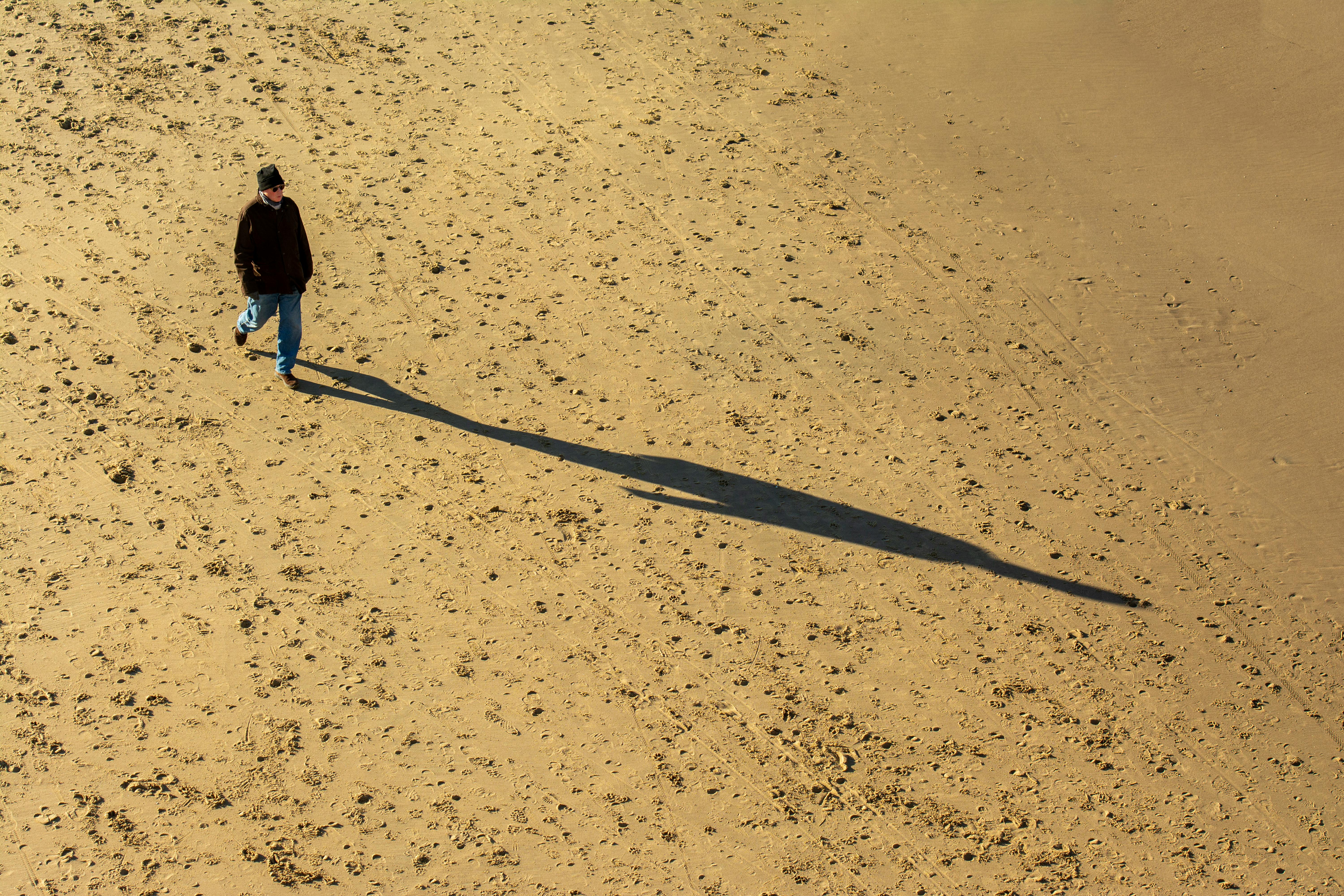 Person Casting Shadow on Sandy Beach · Free Stock Photo