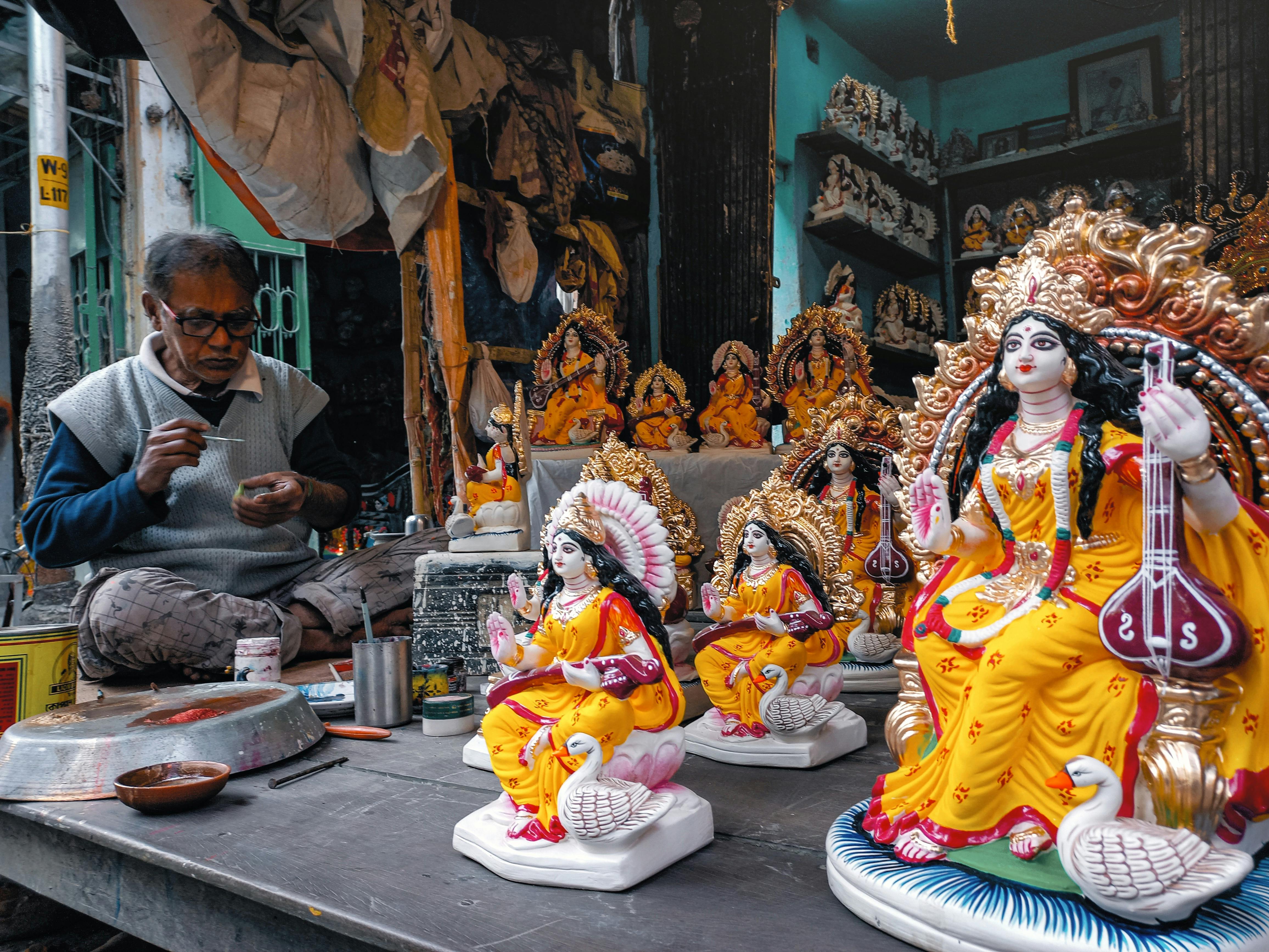 Man Selling Handmade Figurines of Goddesses · Free Stock Photo