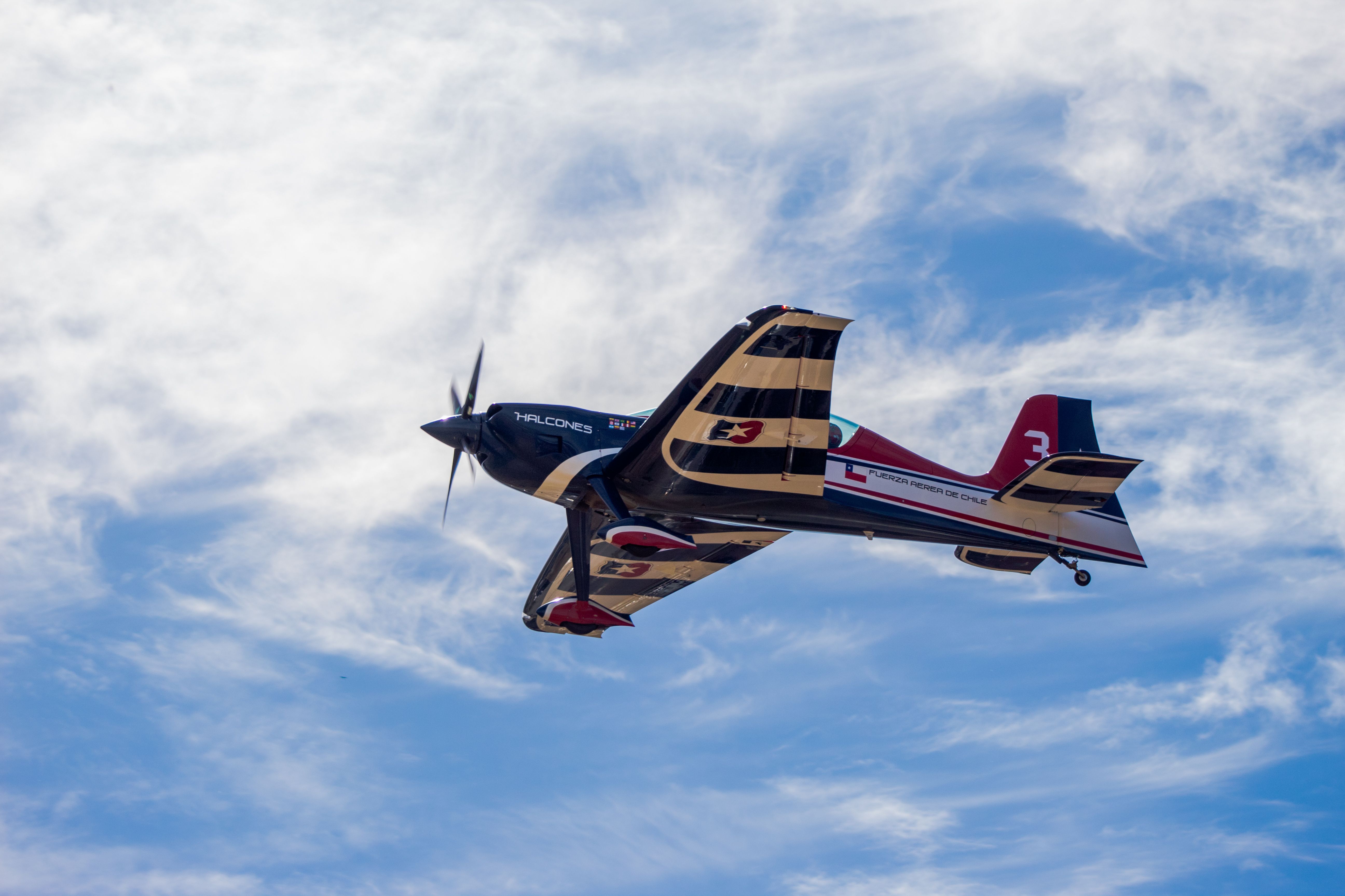 View of a Two-seat Airplane Flying against a Blue Sky with White Clouds ...