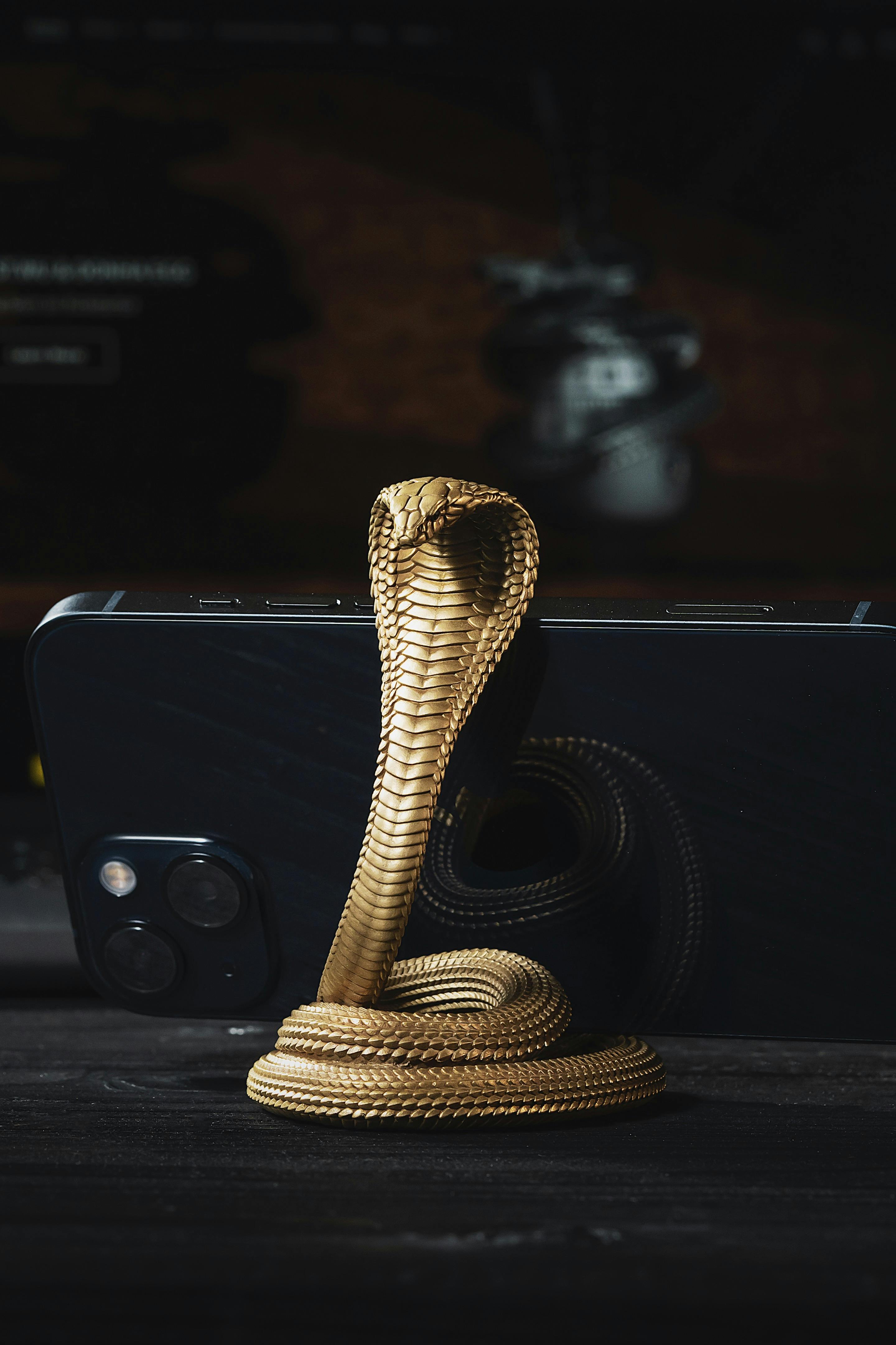 A Phone Standing on a Golden Cobra Phone Stand · Free Stock Photo