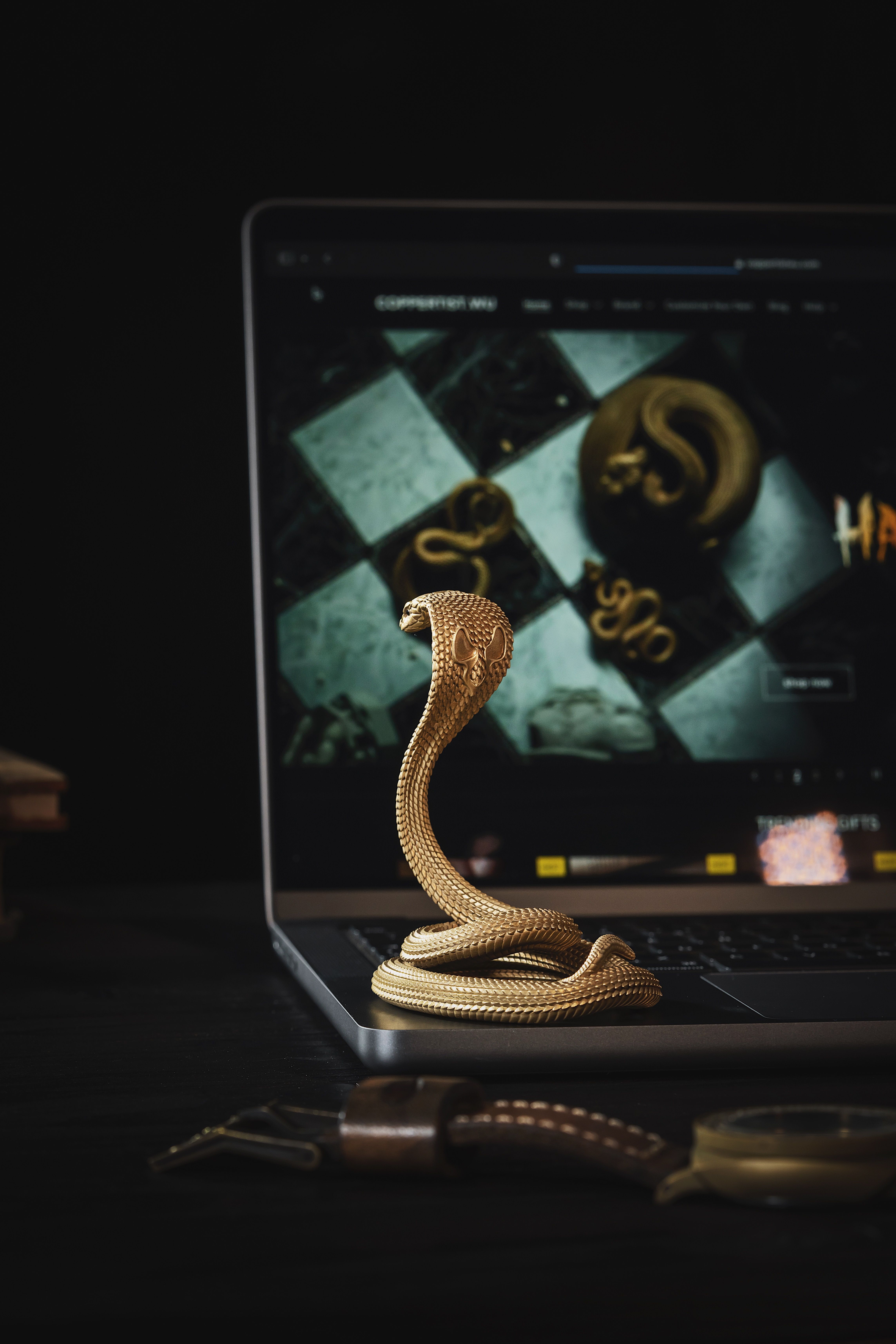 A Handmade, Golden Cobra Phone Stand Standing next to a Laptop · Free ...