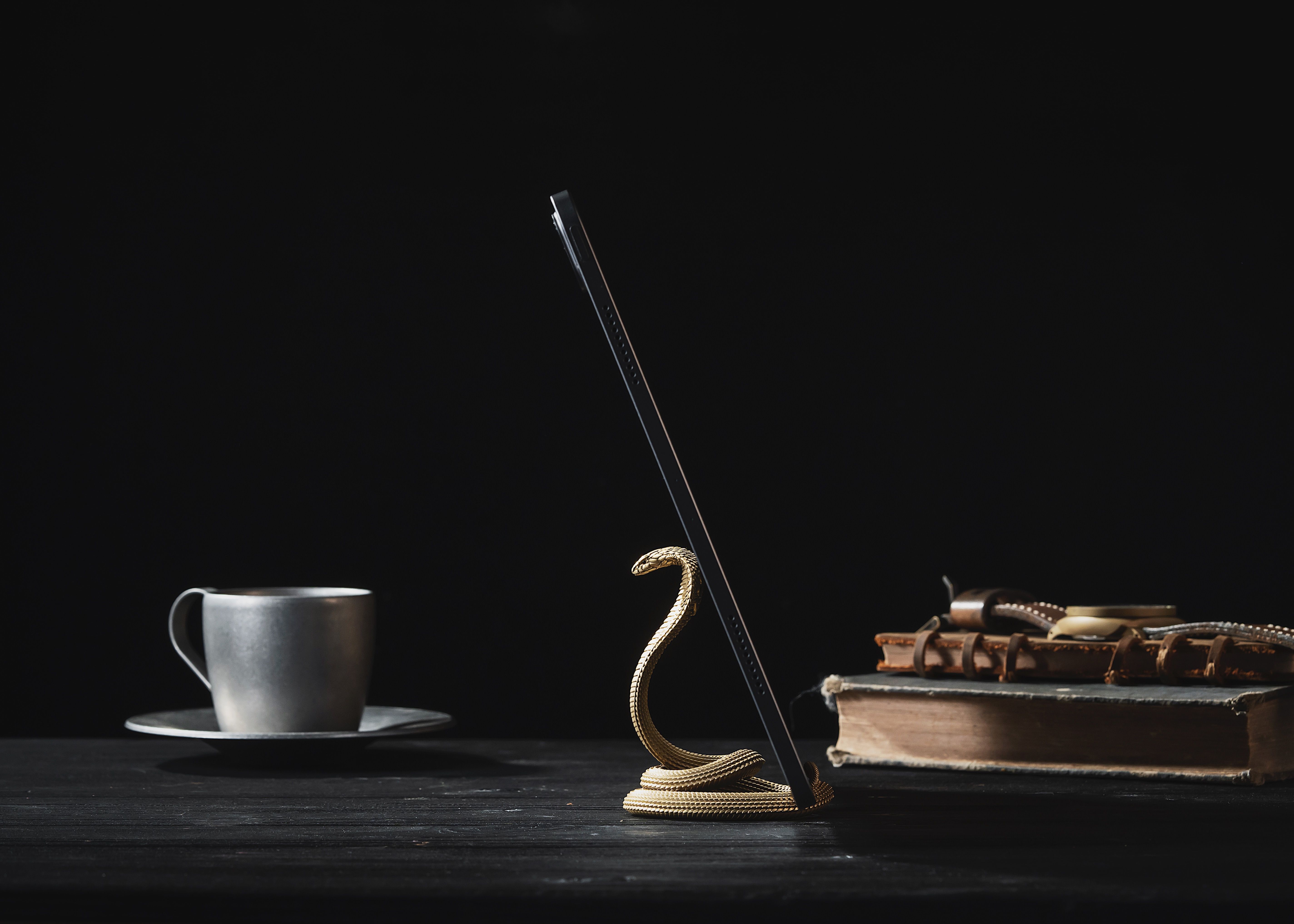 A Tablet Standing on a Handmade, Golden Cobra Stand · Free Stock Photo