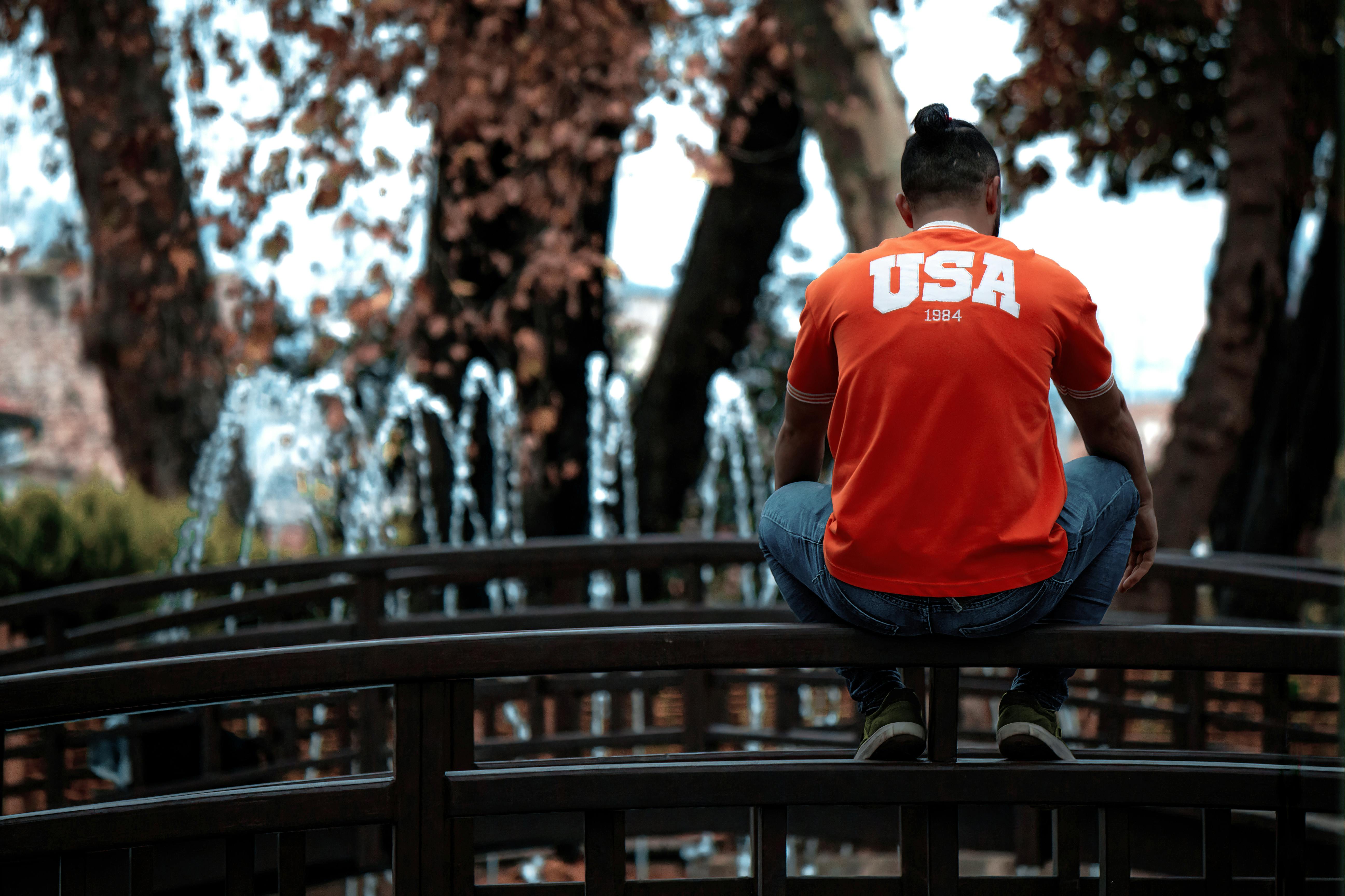 Man Sitting on Footbridges Handrail · Free Stock Photo