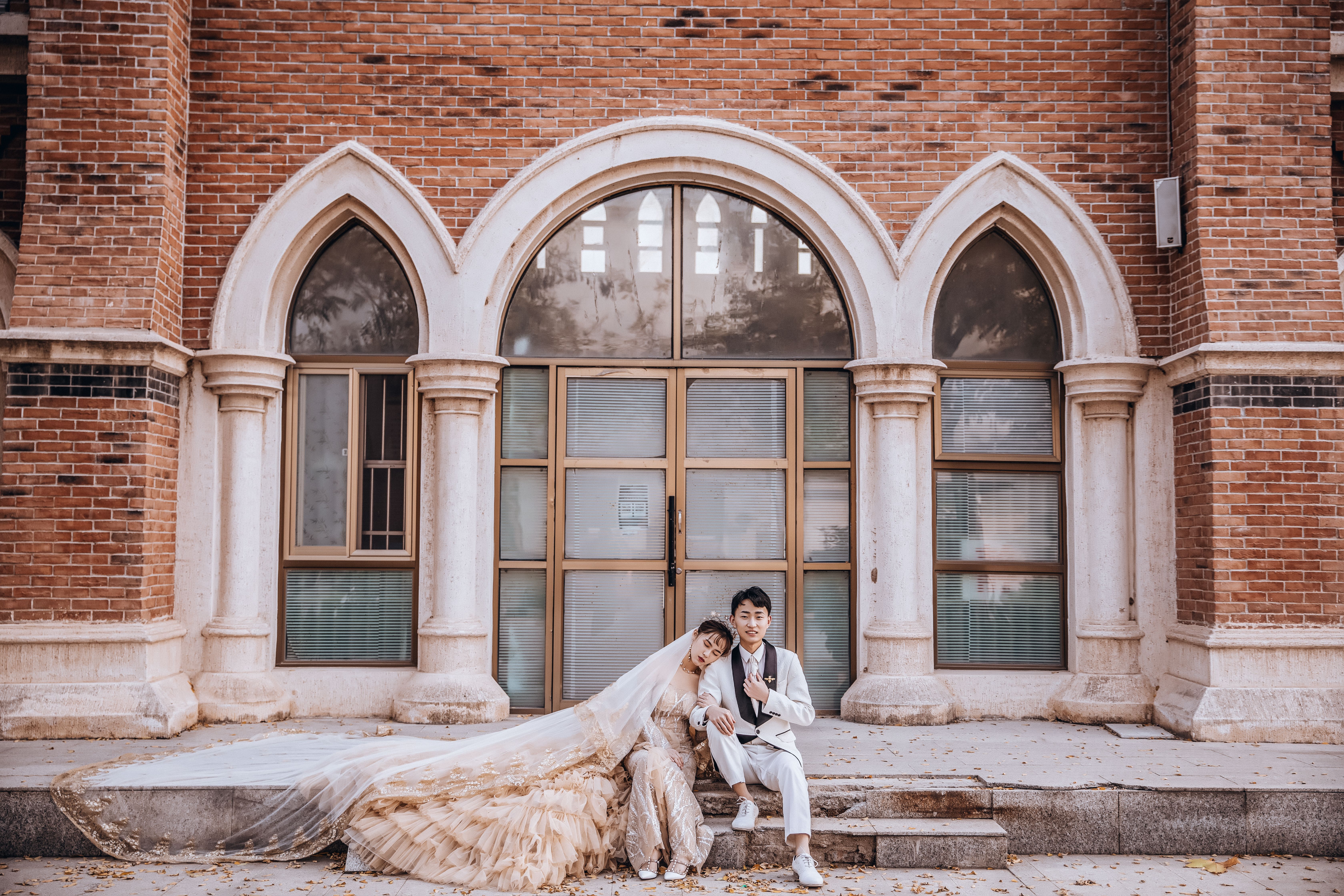 Young Bride and Groom Sitting Together in front of a Building · Free ...