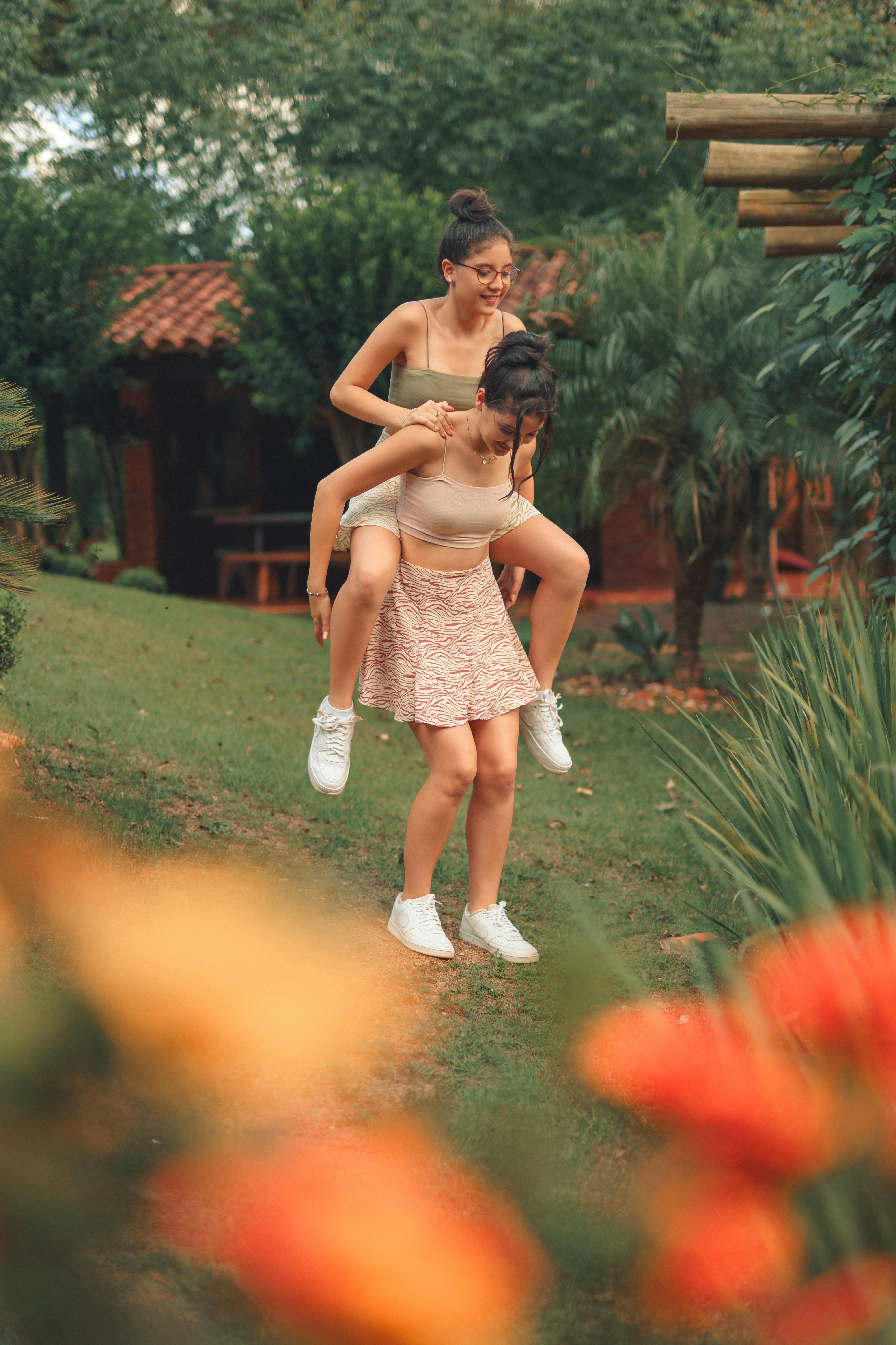 Smiling Girl Giving Piggyback Ride to Her Friend · Free Stock Photo
