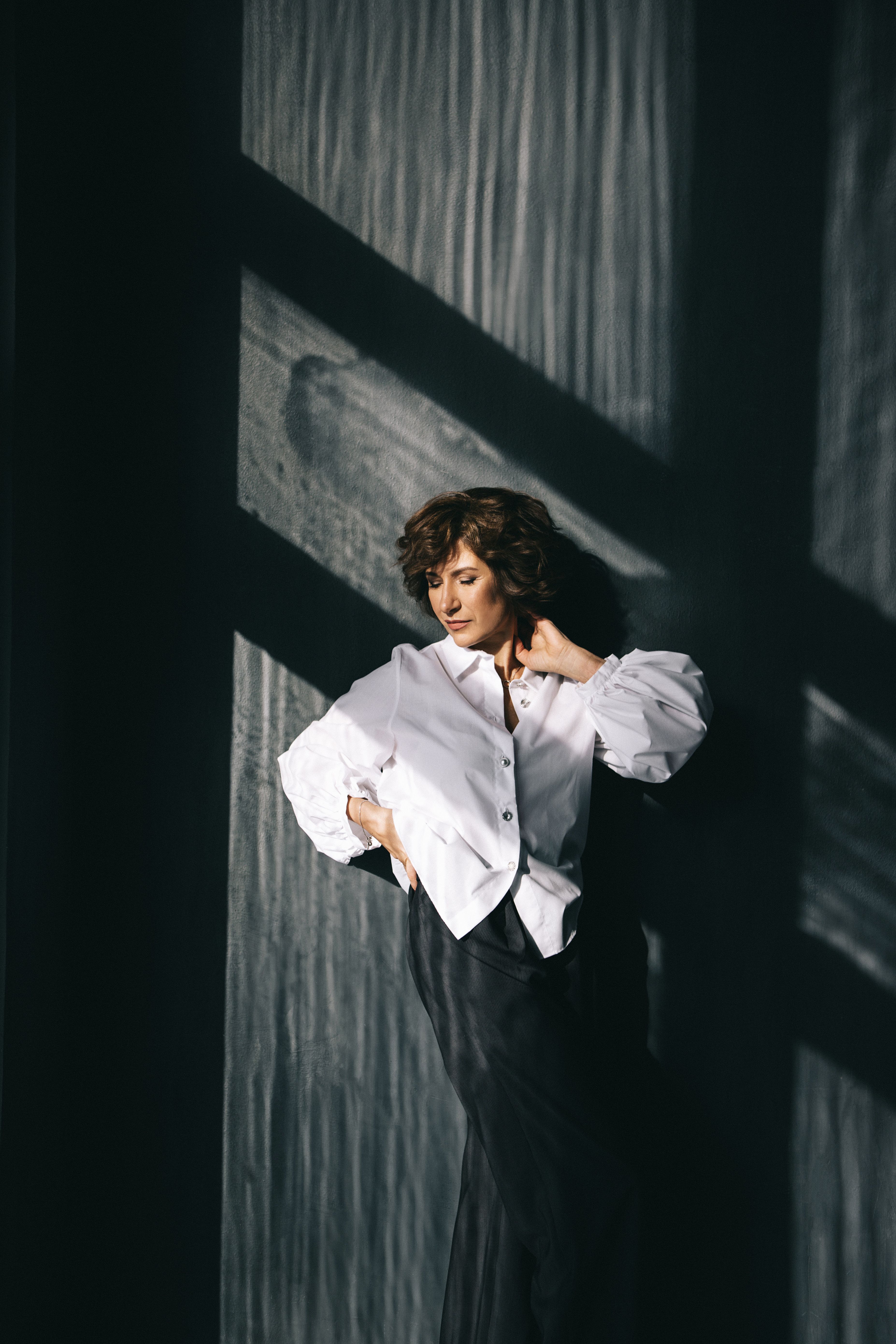Woman Posing in Shadow near Wall · Free Stock Photo