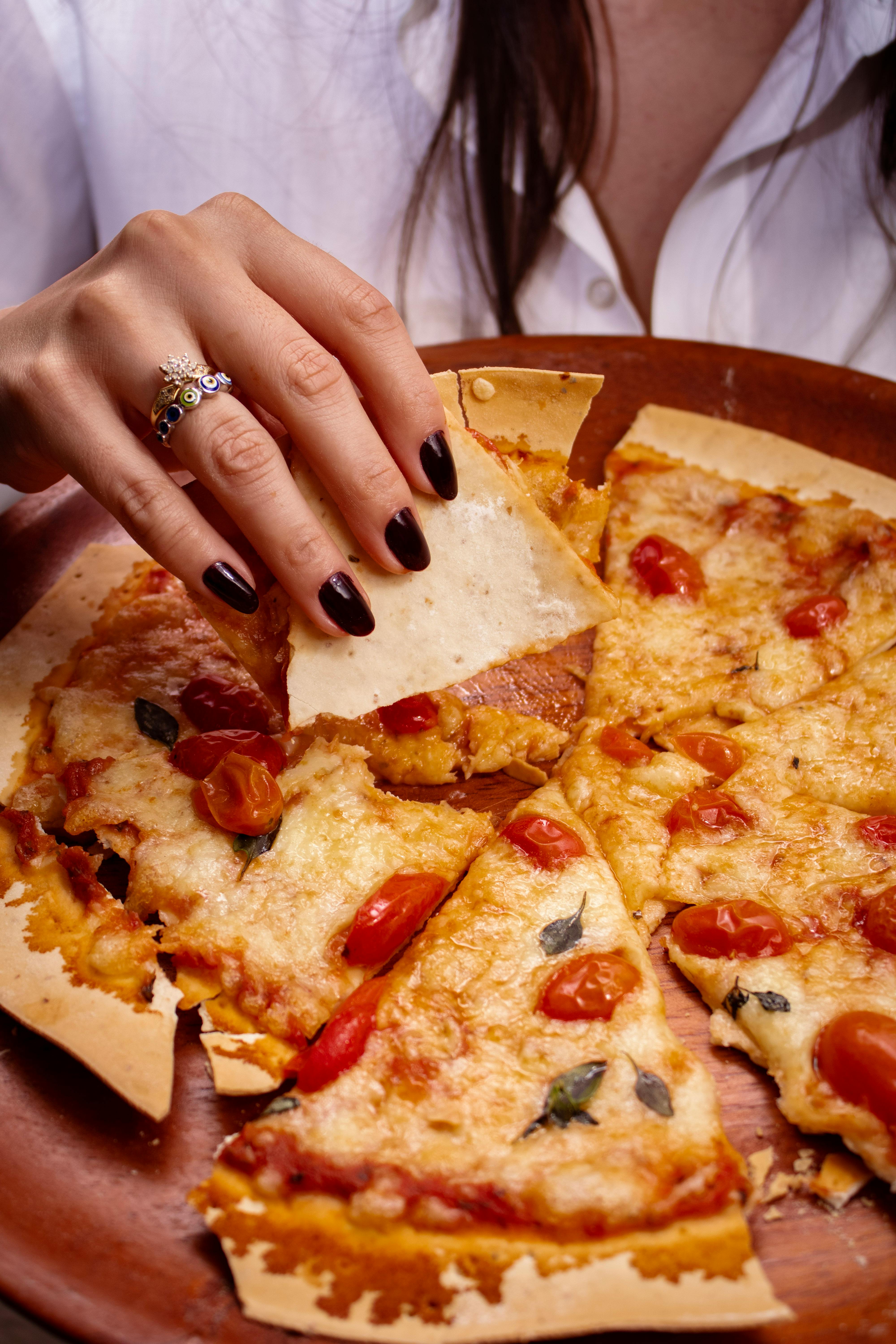 Woman Hand Holding Pizza Slice · Free Stock Photo
