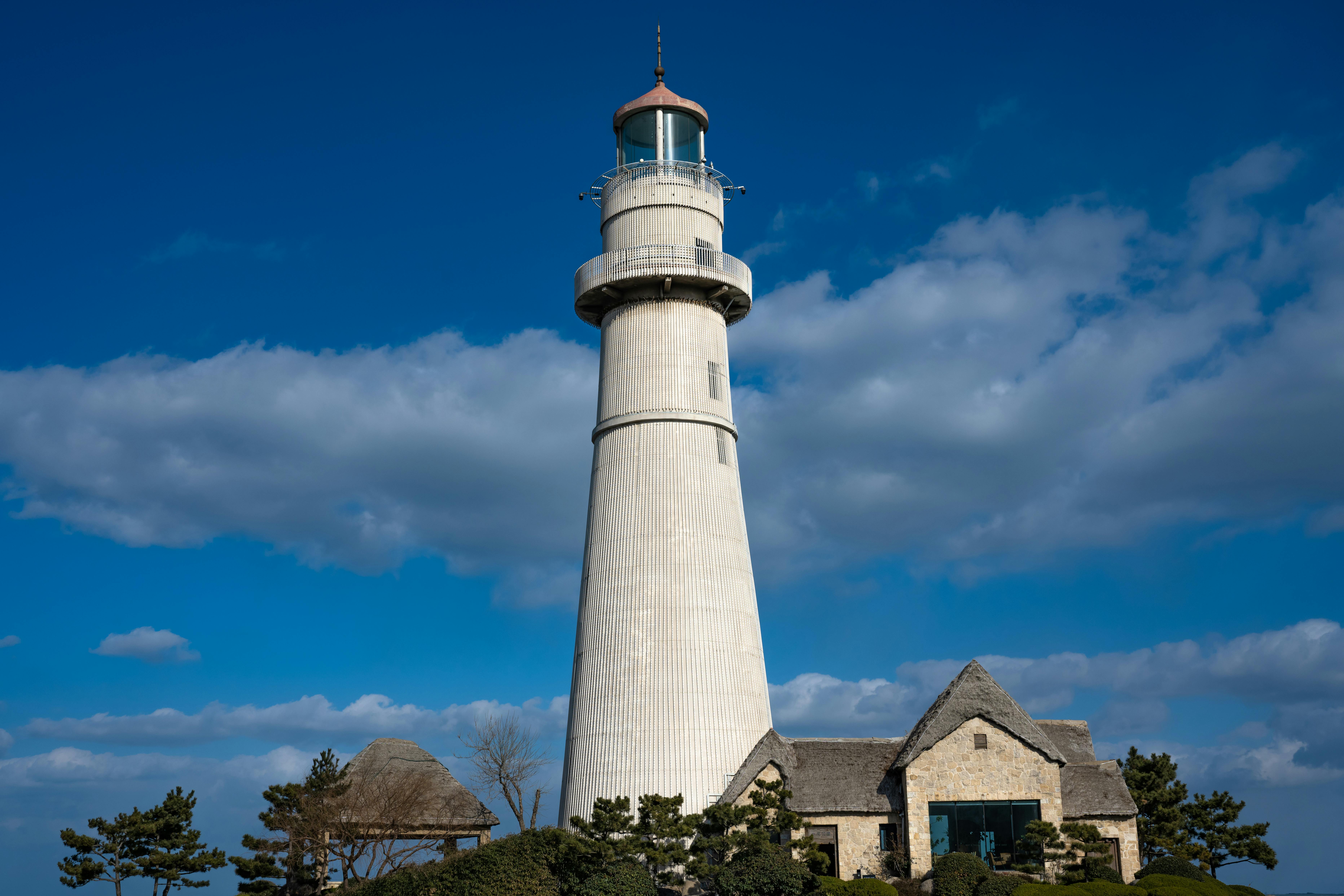 White Lighthouse Under Blue Sky and White Clouds · Free Stock Photo
