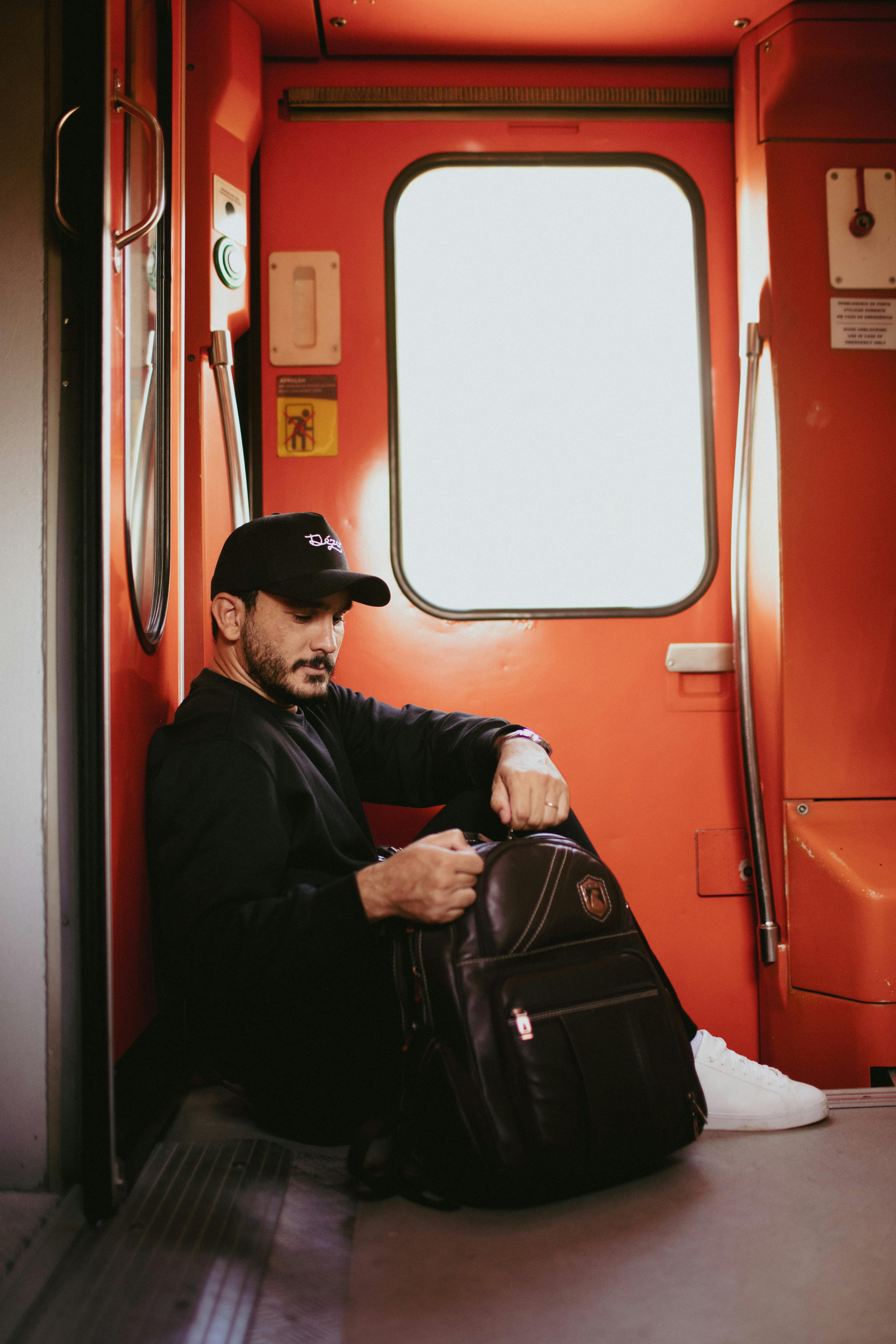 Man Sitting on Floor in Train Corridor · Free Stock Photo