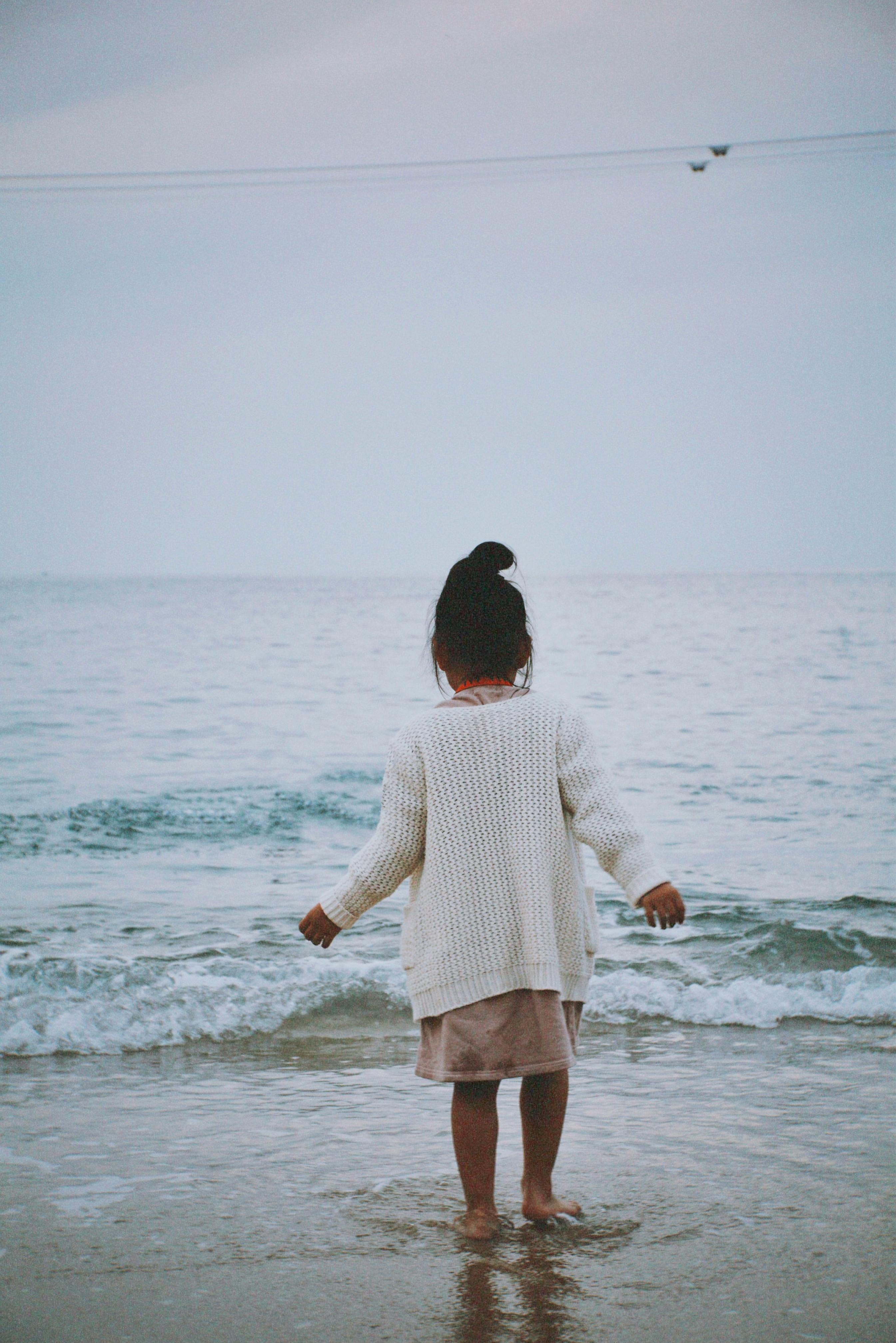 Back View of Girl Standing on Sea Shore · Free Stock Photo