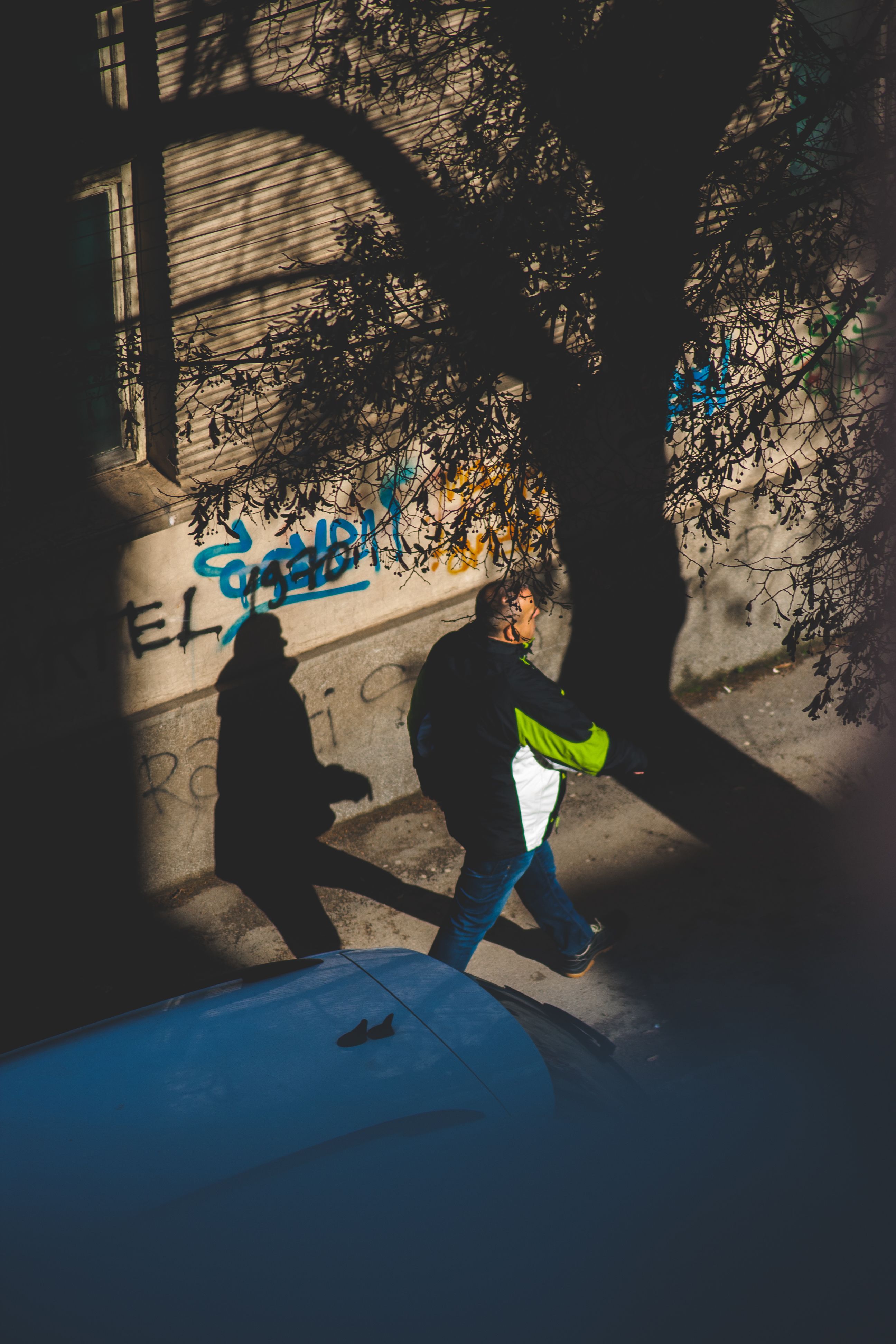 Man and His Shadow Walking along the Street · Free Stock Photo