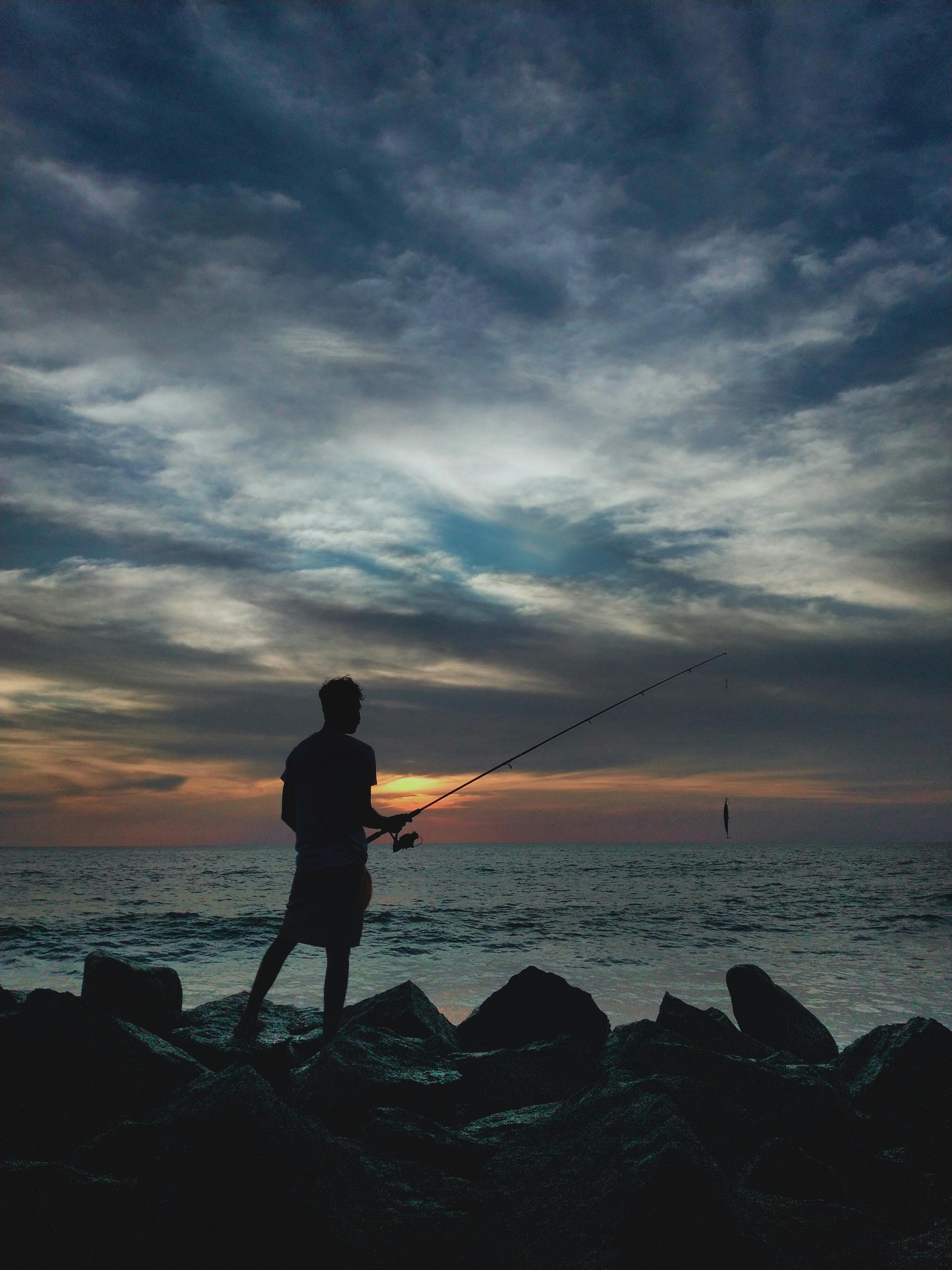 Man with Fishing Rod by Sea at Dawn · Free Stock Photo