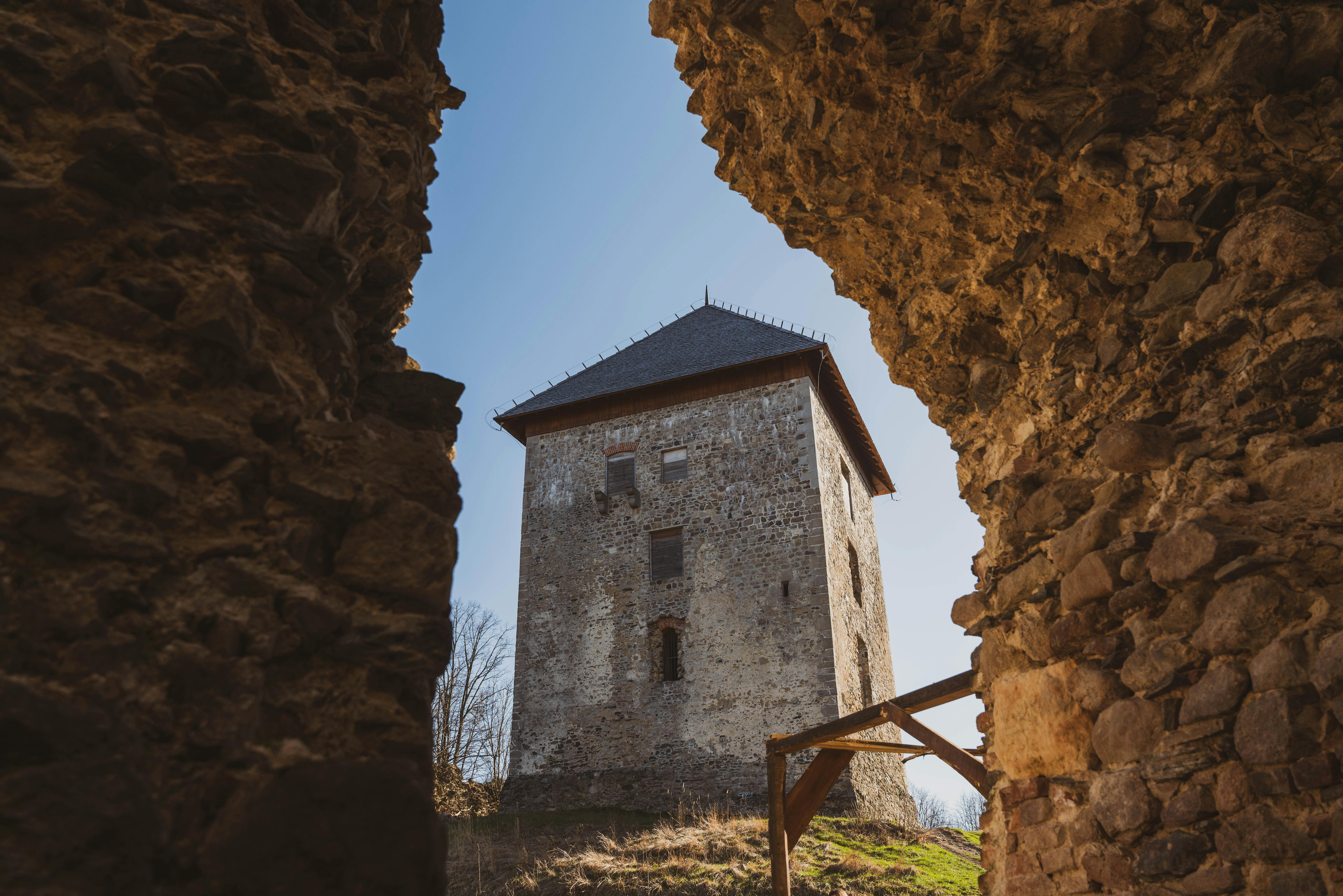 A Tower of a Castle seen between Stone Walls · Free Stock Photo