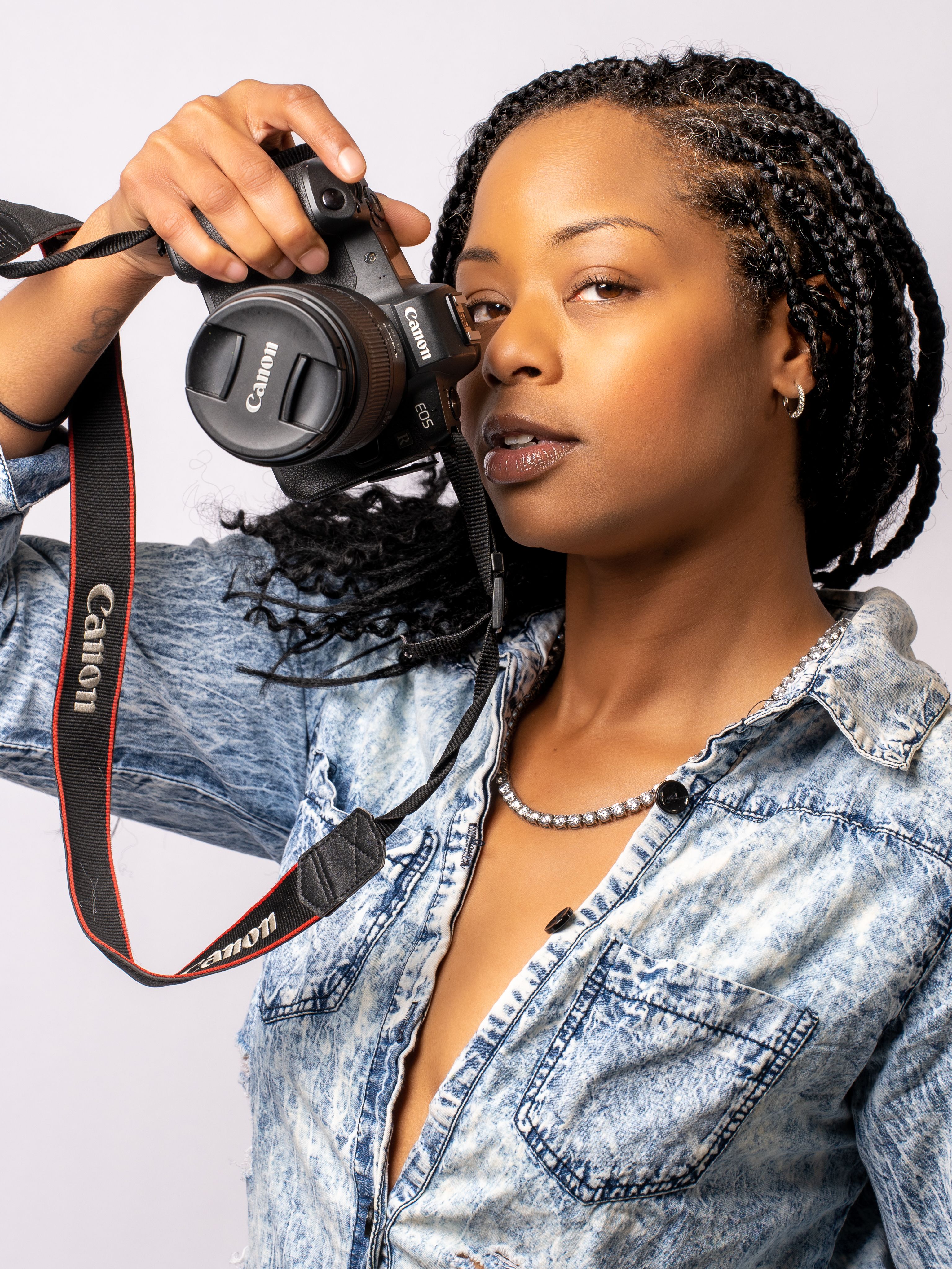Woman in Denim Dress Posing with Camera in Hand · Free Stock Photo