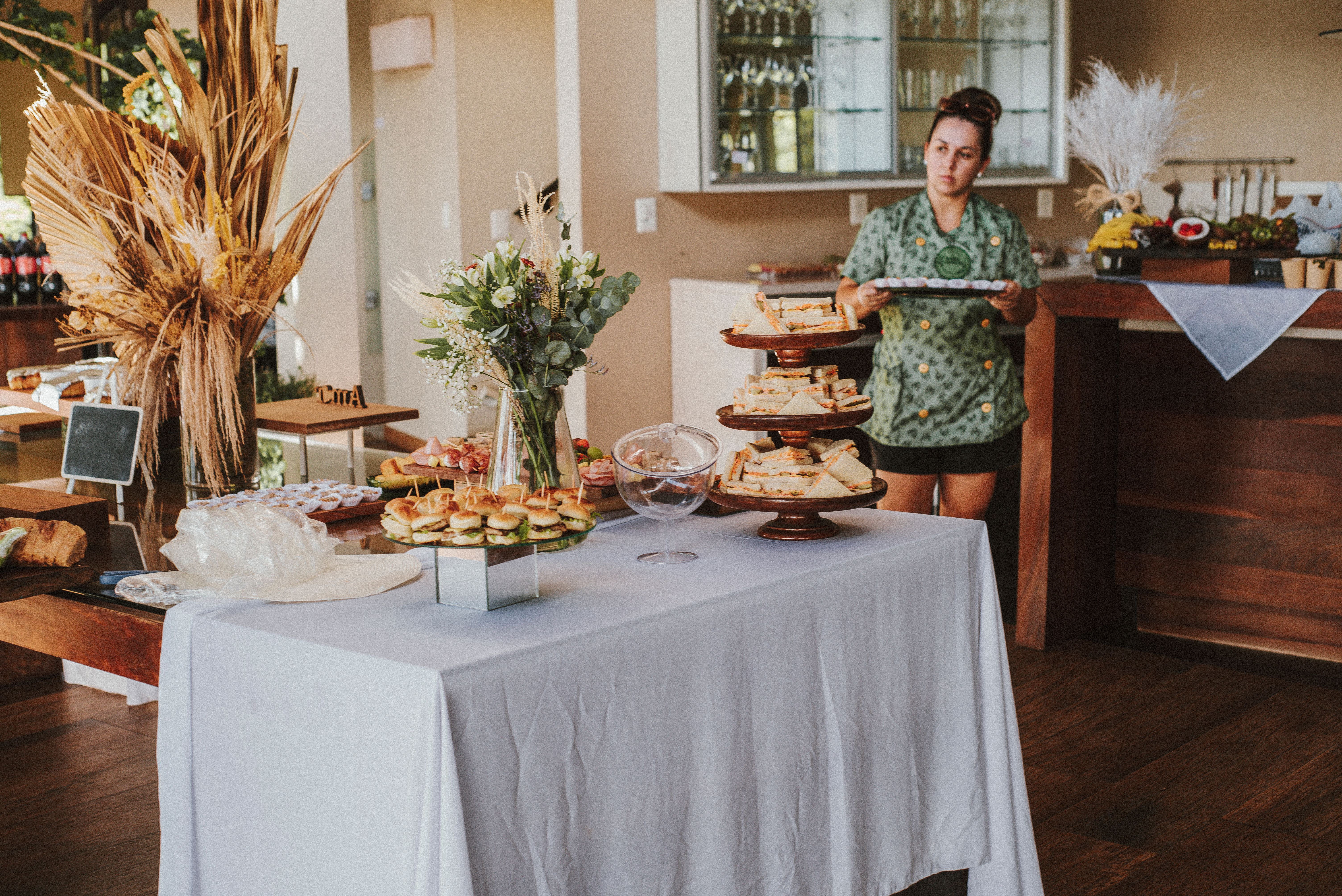 Woman Bringing Food to a Set Table with Snacks · Free Stock Photo