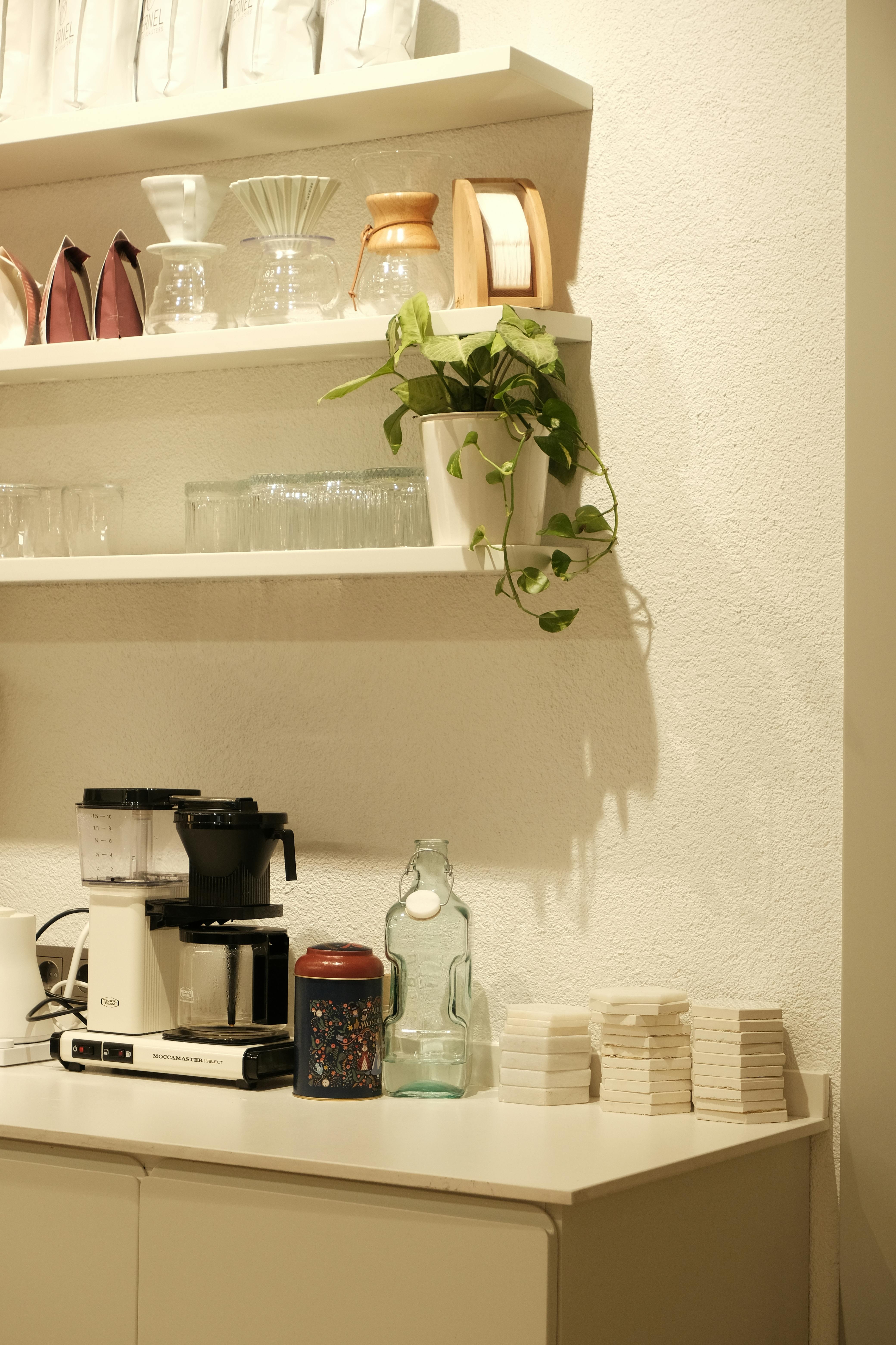 A Coffee Machine on the Countertop and Glasses and Bags of Coffee on ...