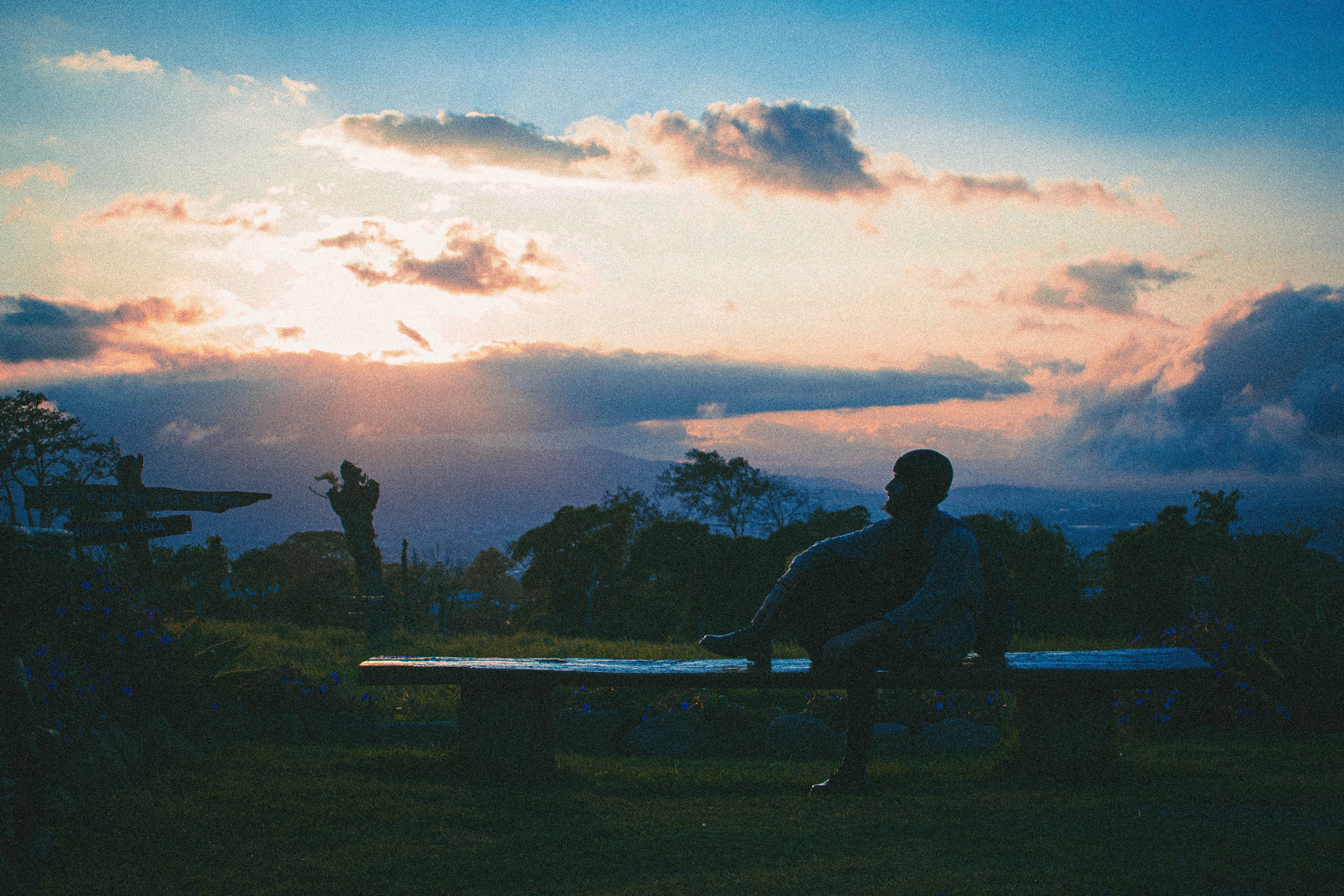 Silhouette of a Man Sitting on a Bench at Sunset · Free Stock Photo