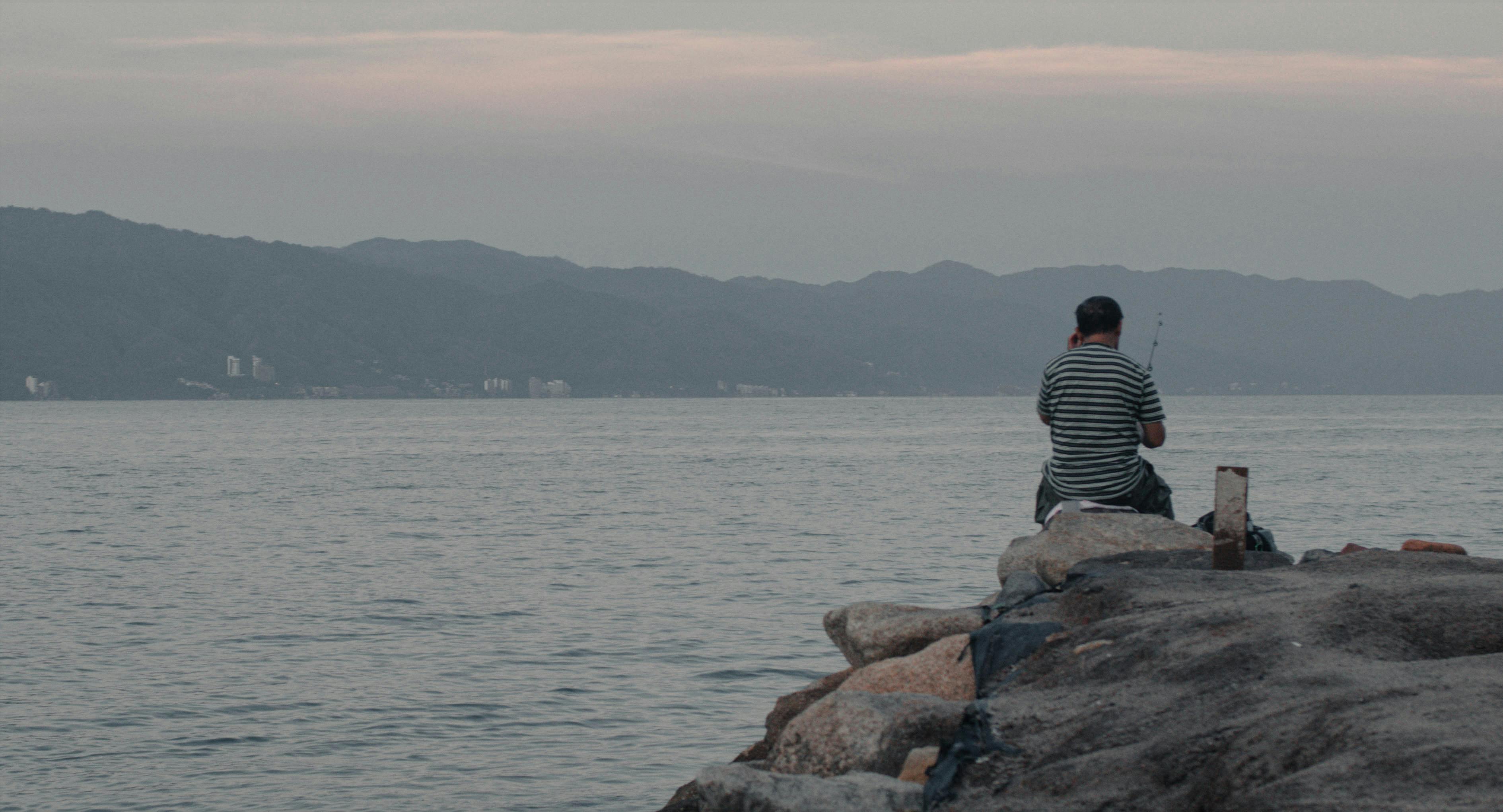 Man on Rock on Sea Shore · Free Stock Photo