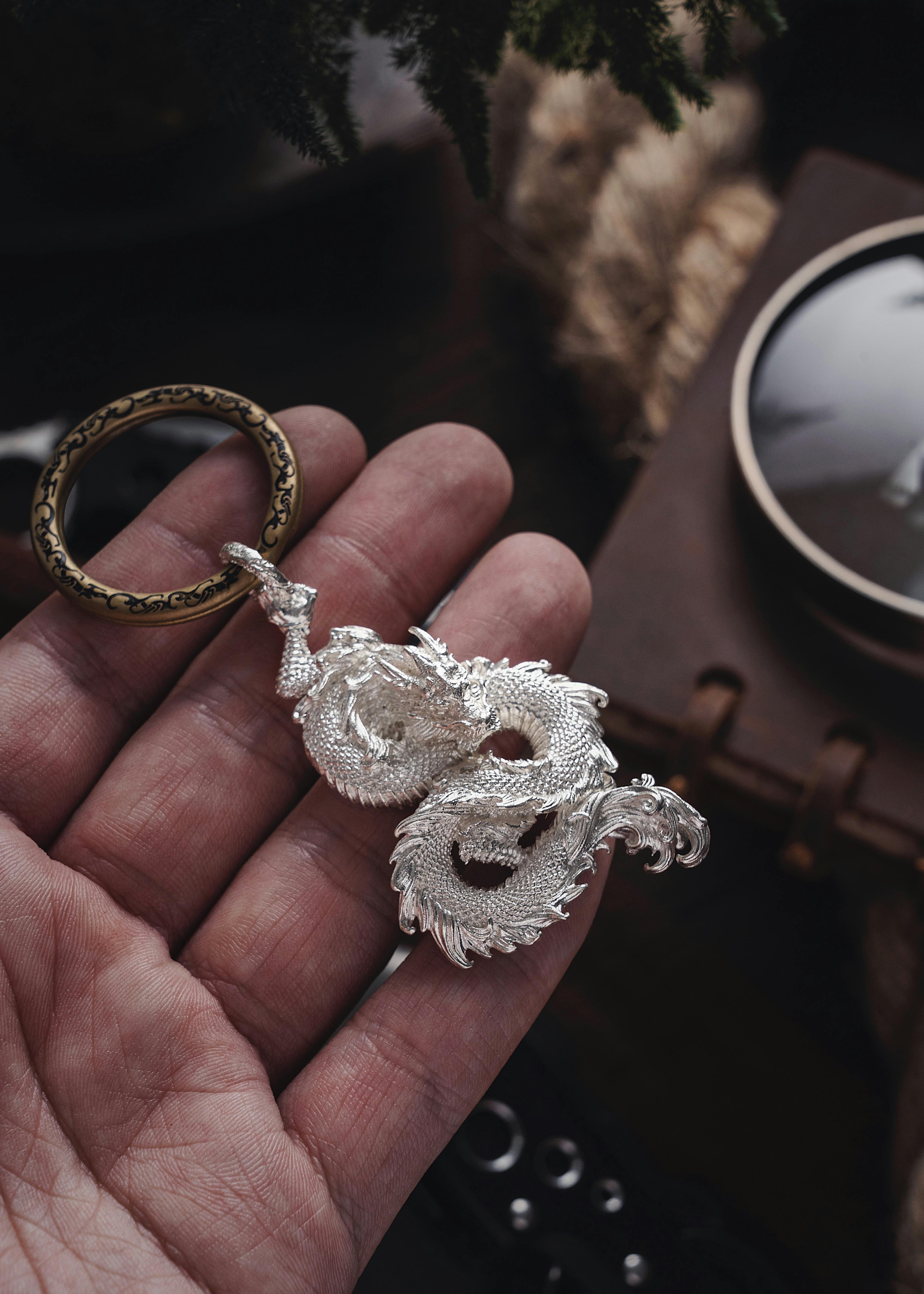 Hand Holding a Vintage Dragon Key Chain · Free Stock Photo