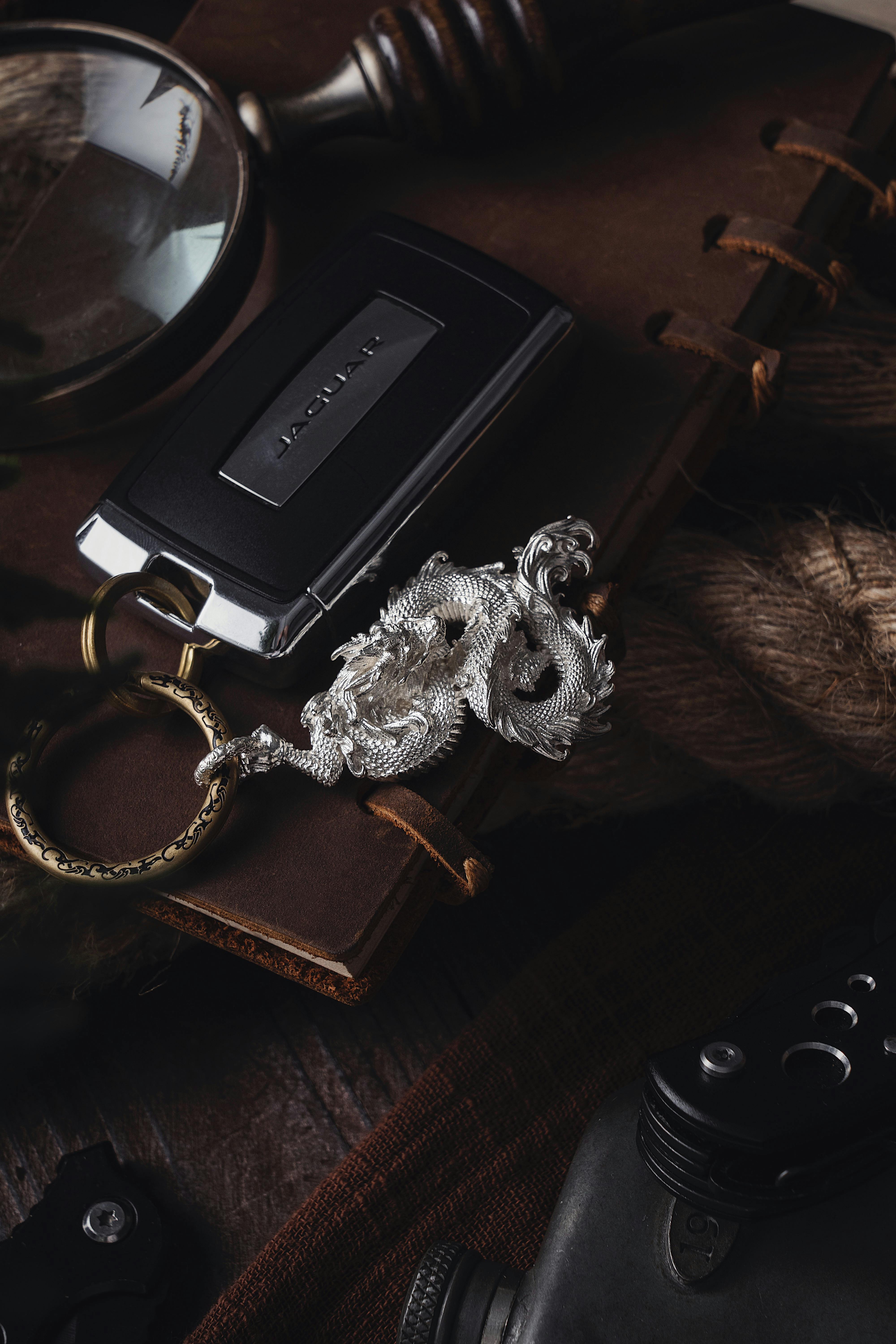 Silver Dragon Key Chain and a Magnifying Glass · Free Stock Photo