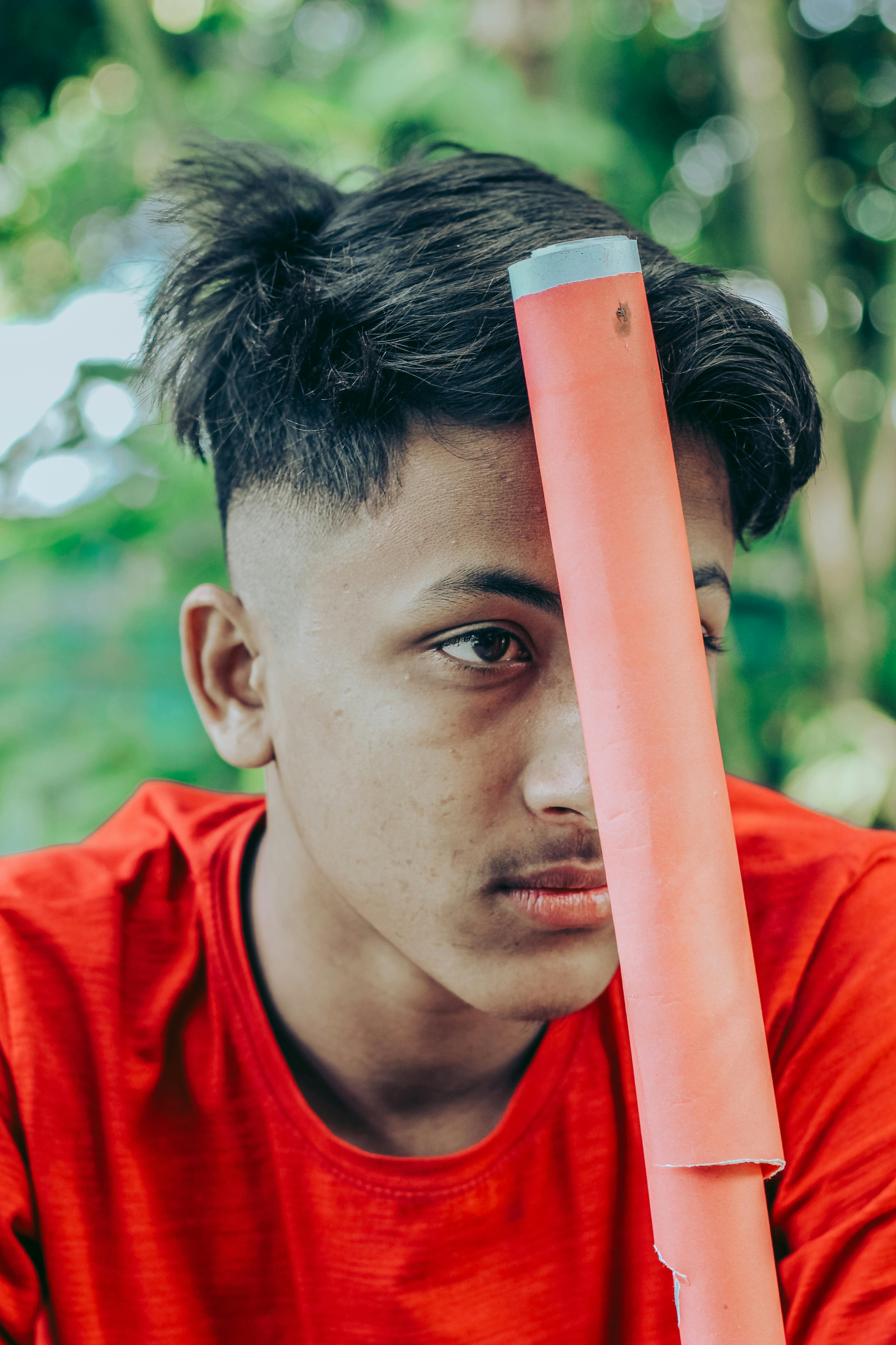 Teenage Boy Holding a Roll of Paper · Free Stock Photo