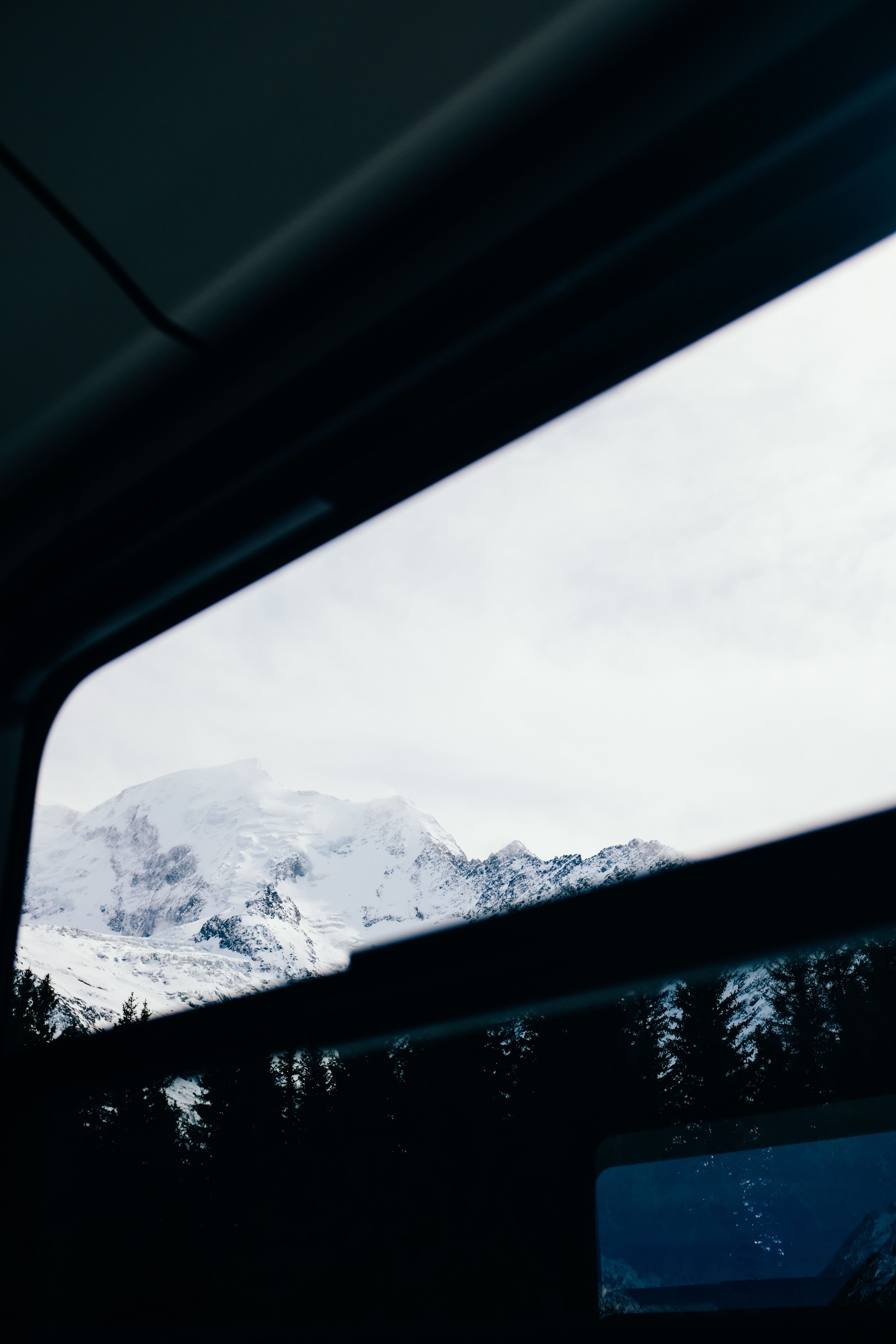 Forest and Mountains in Snow behind Train Windows · Free Stock Photo